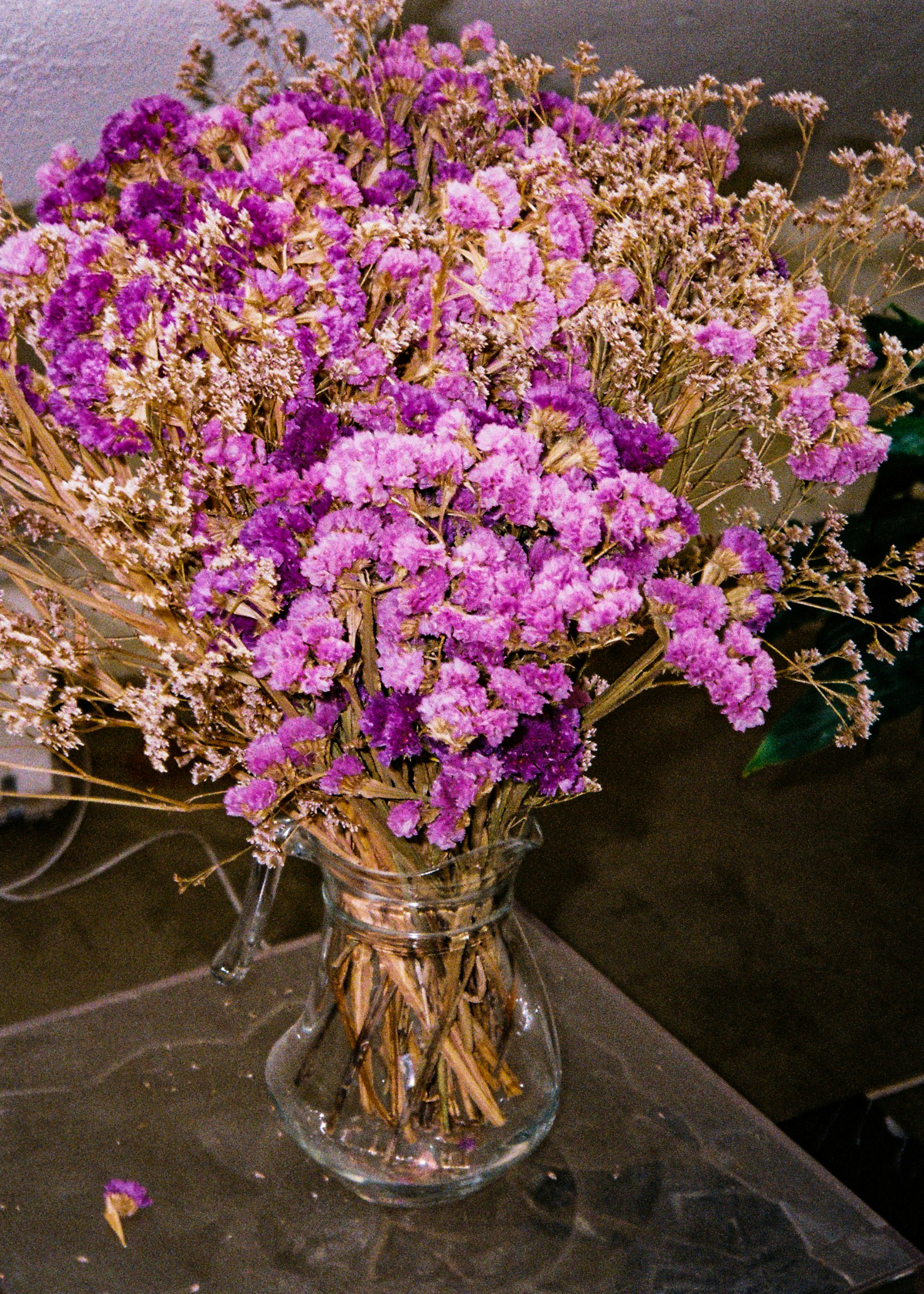 A vibrant bouquet of dried purple flowers elegantly arranged in a glass vase, capturing the essence of nature's beauty in a timeless display.