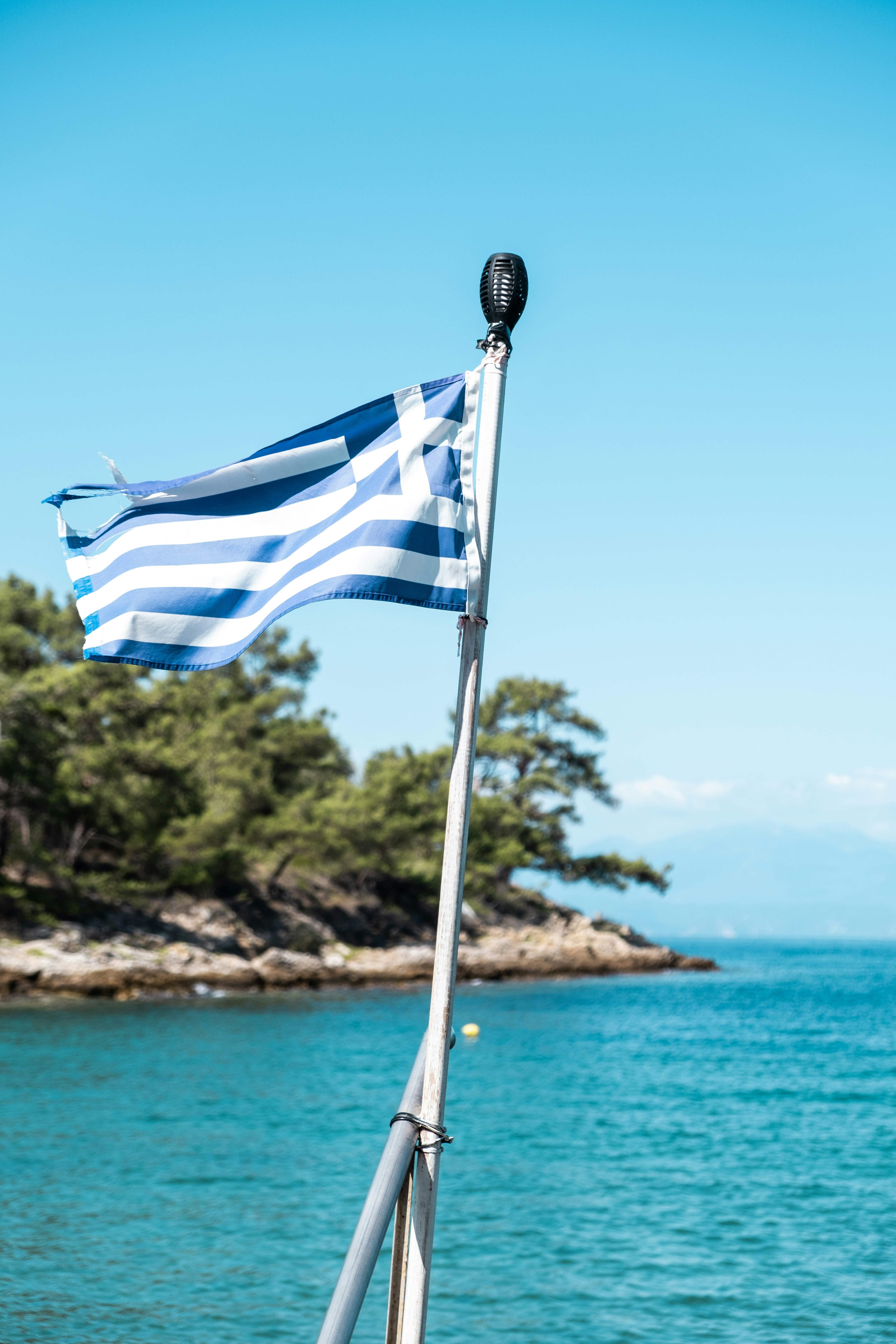 Flag Over Cerulean Waters: Aegean Breeze in Blue