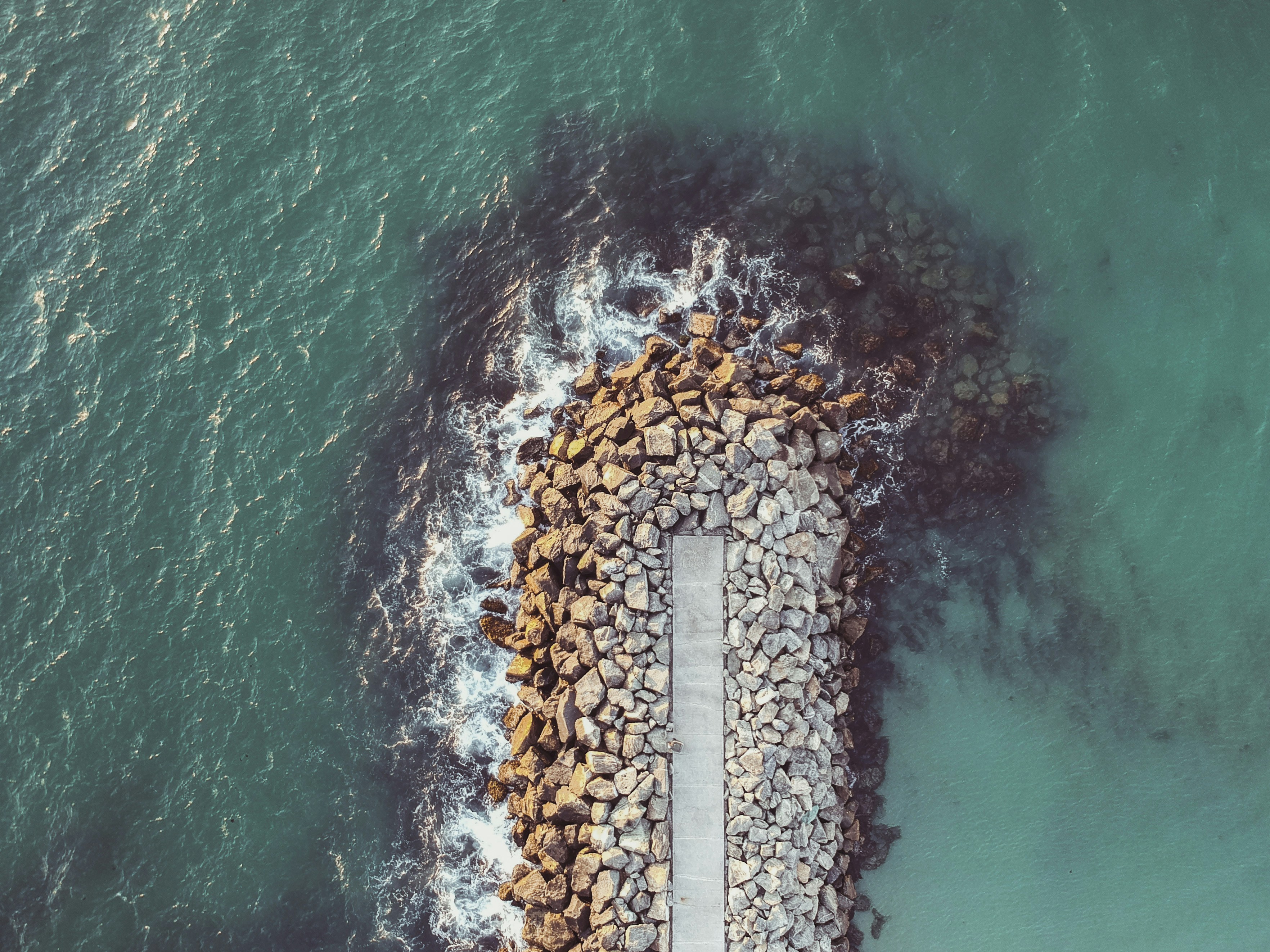 Une vue aérienne d’une jetée avec des rochers et de l’eau photo – Photo ...