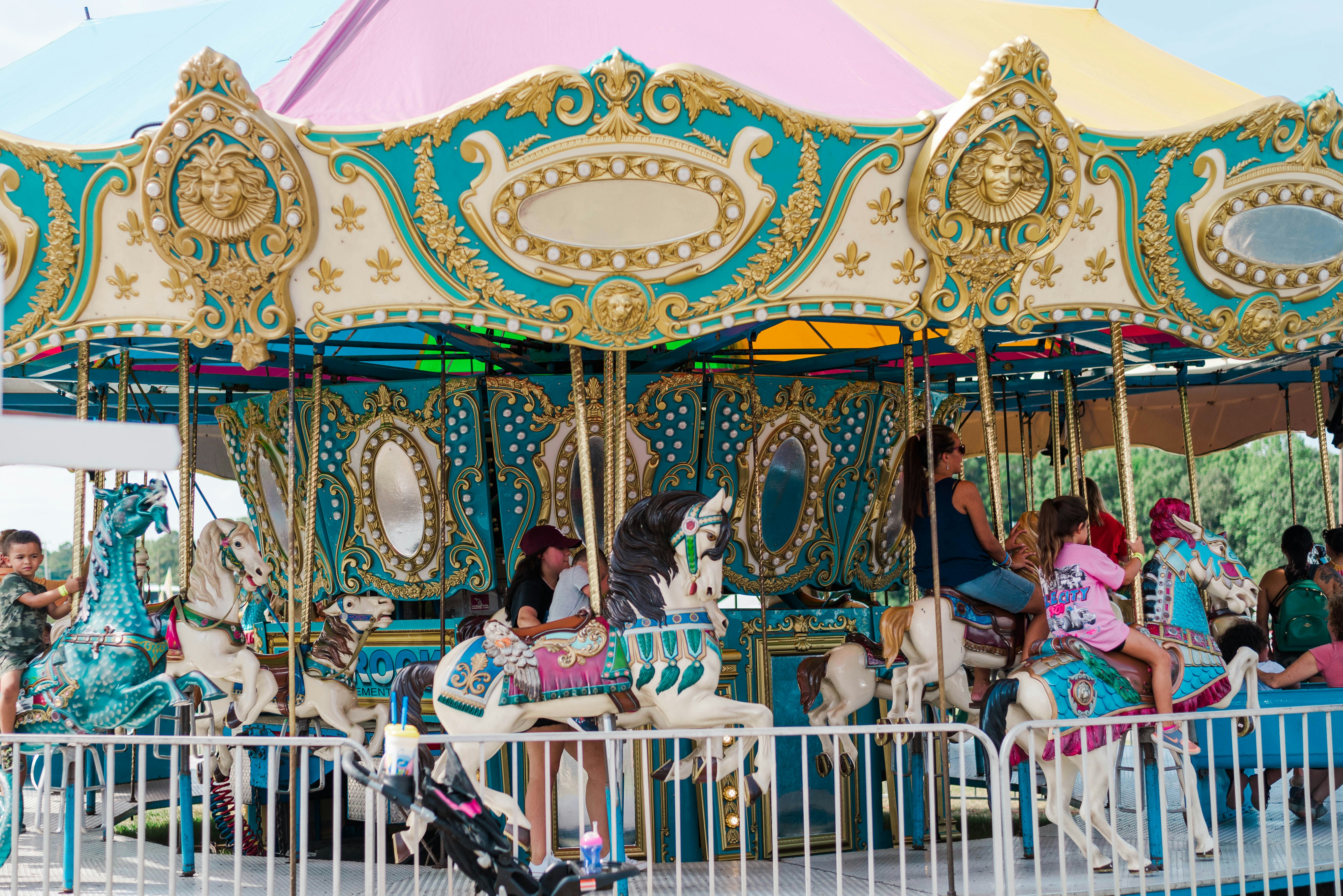 A group of people riding on top of a carousel photo – Free Carousel ...