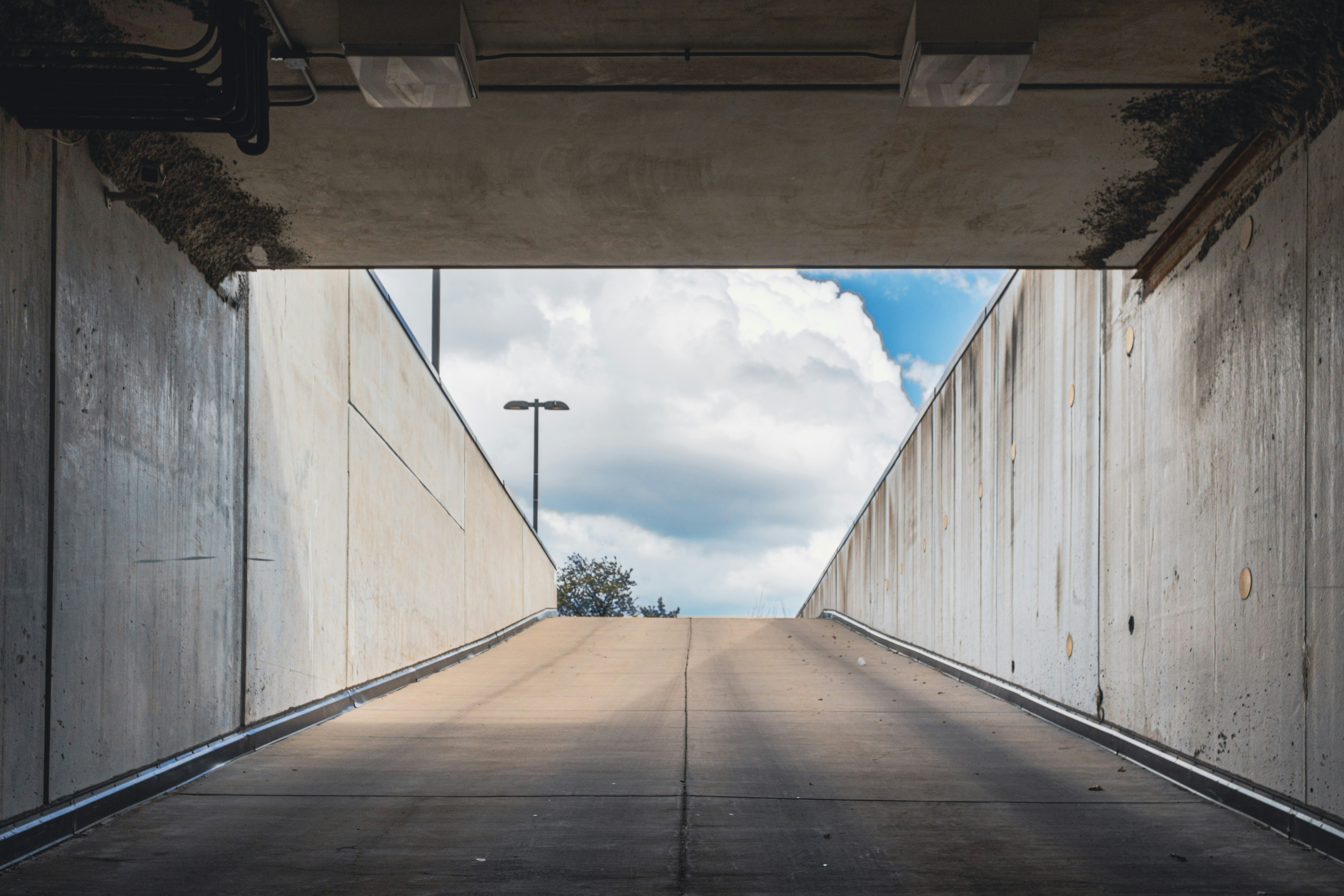 An empty concrete walkway with a street light in the distance photo ...