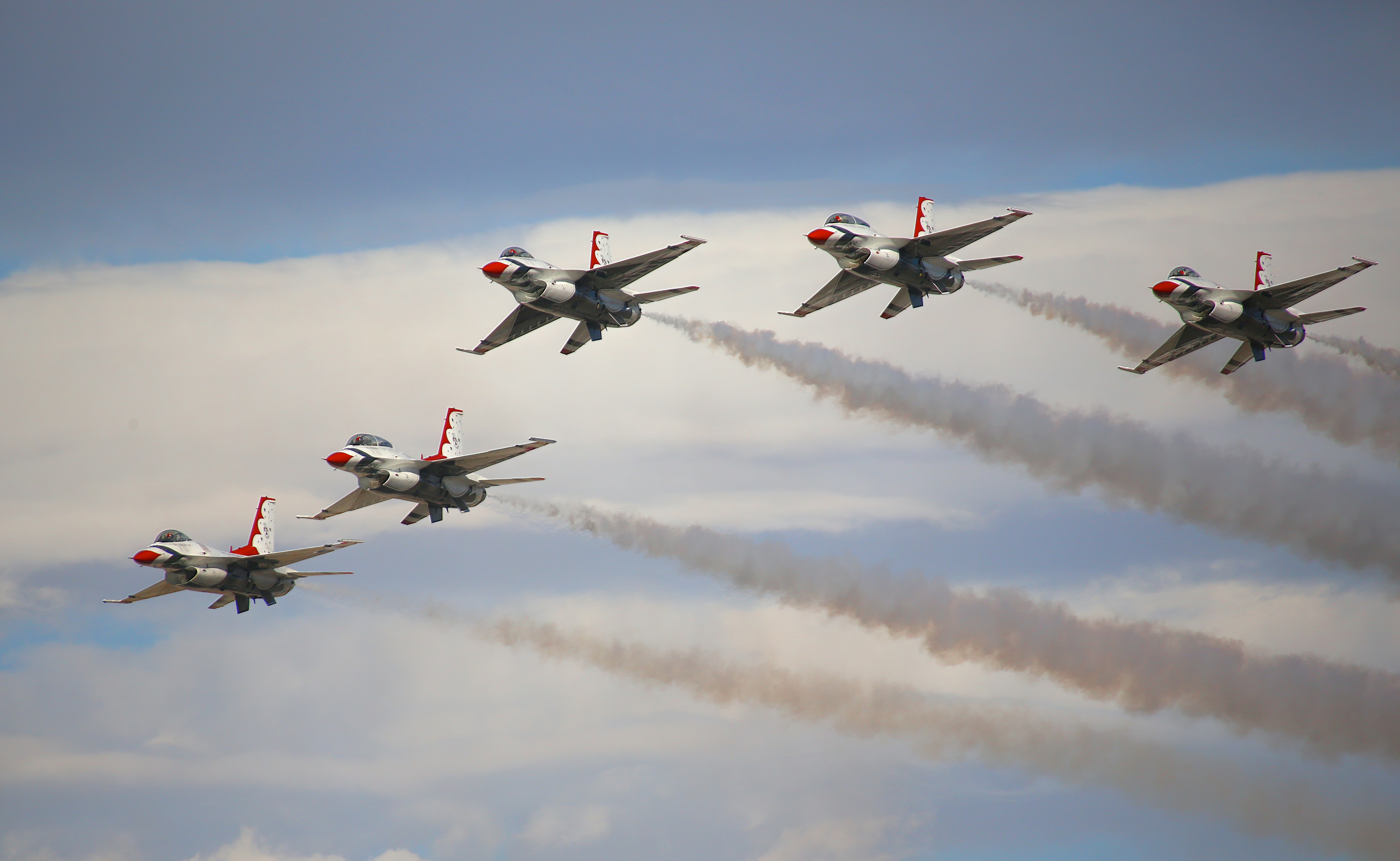A group of fighter jets flying through a cloudy sky photo – Free Reno ...