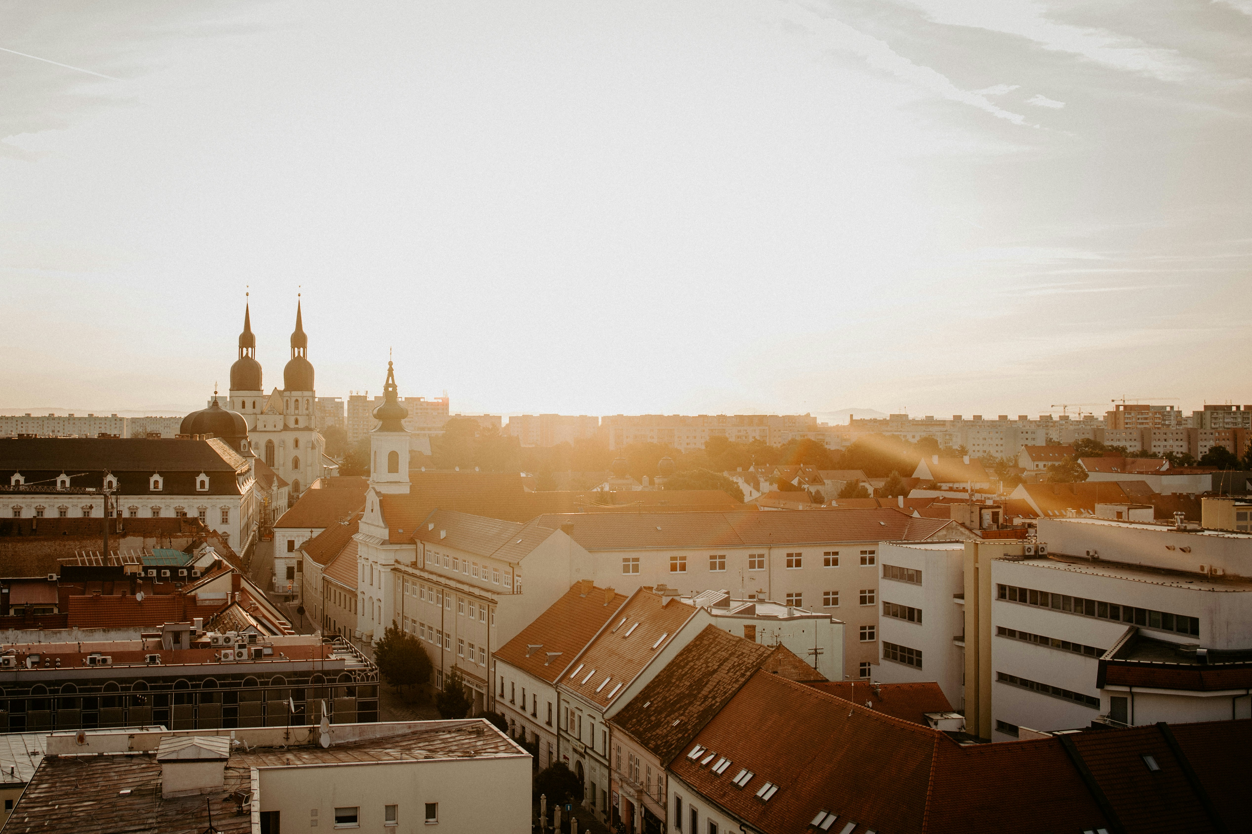 Sunrise illuminating Trnava's historic buildings and rooftops from a high vantage point.