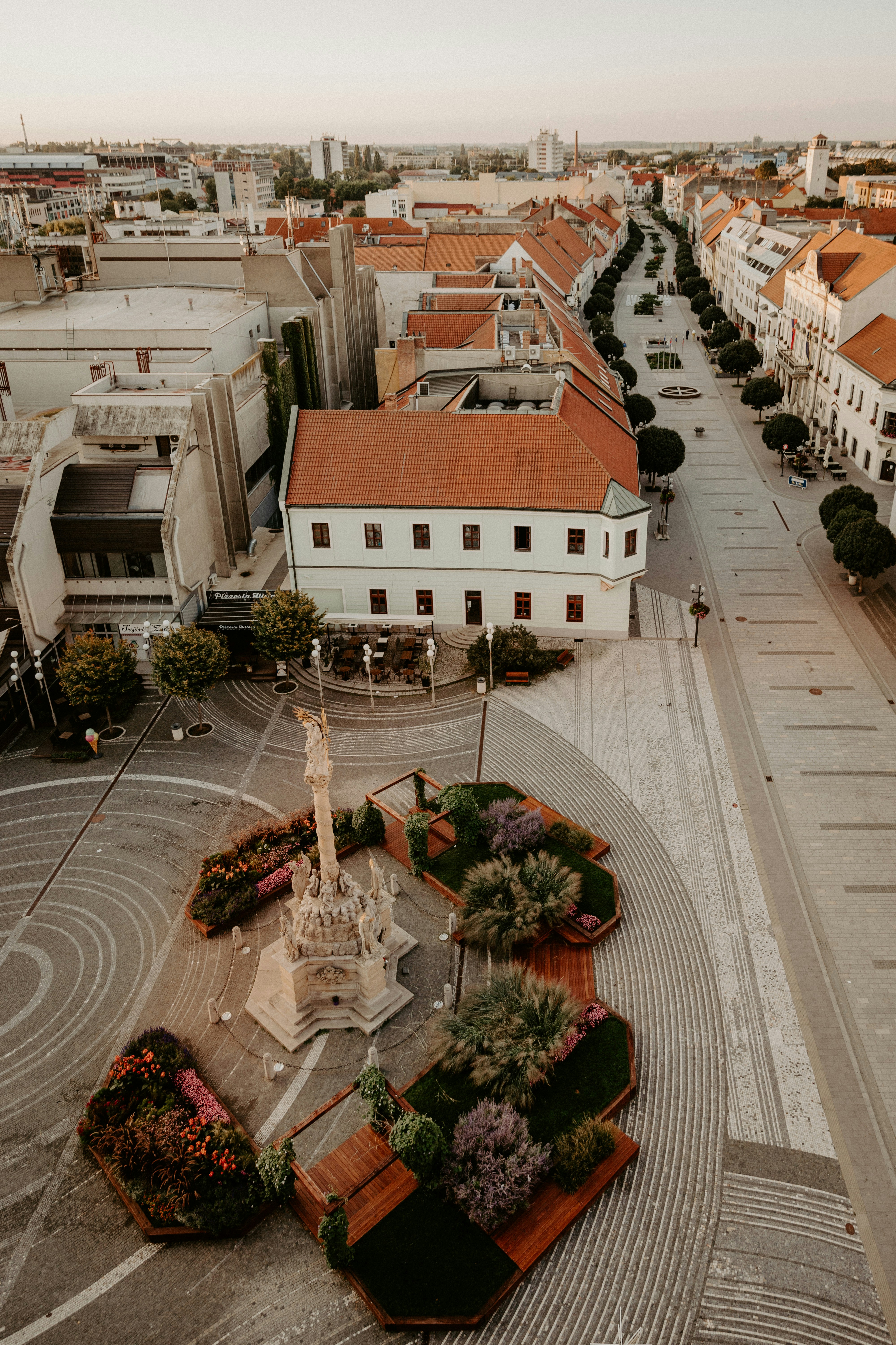 Elegant garden centerpiece featuring vibrant flowers and greenery, surrounded by historical architecture and a serene street view.