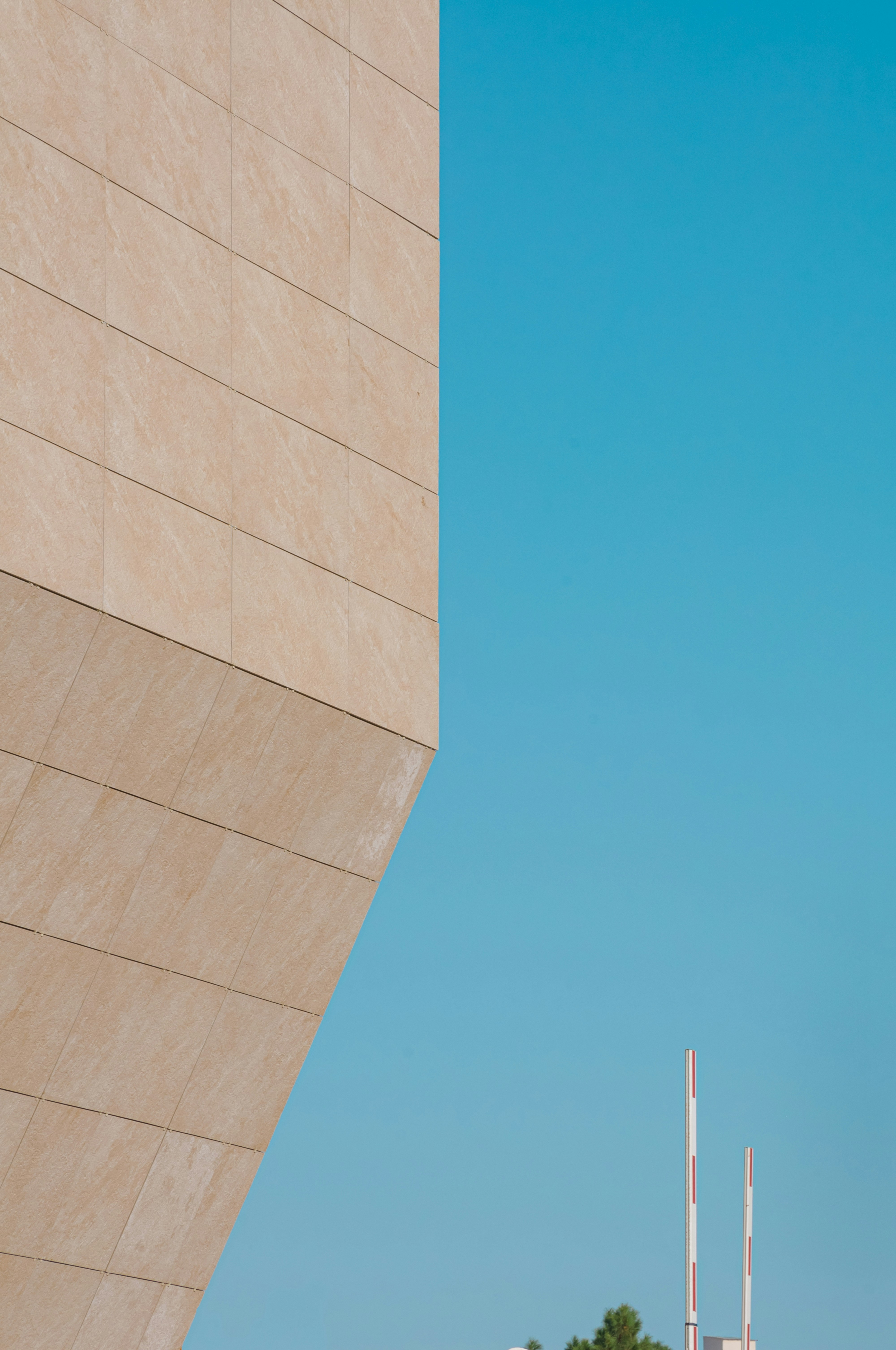 A plane flying in the sky over a building photo – Free Marble ...