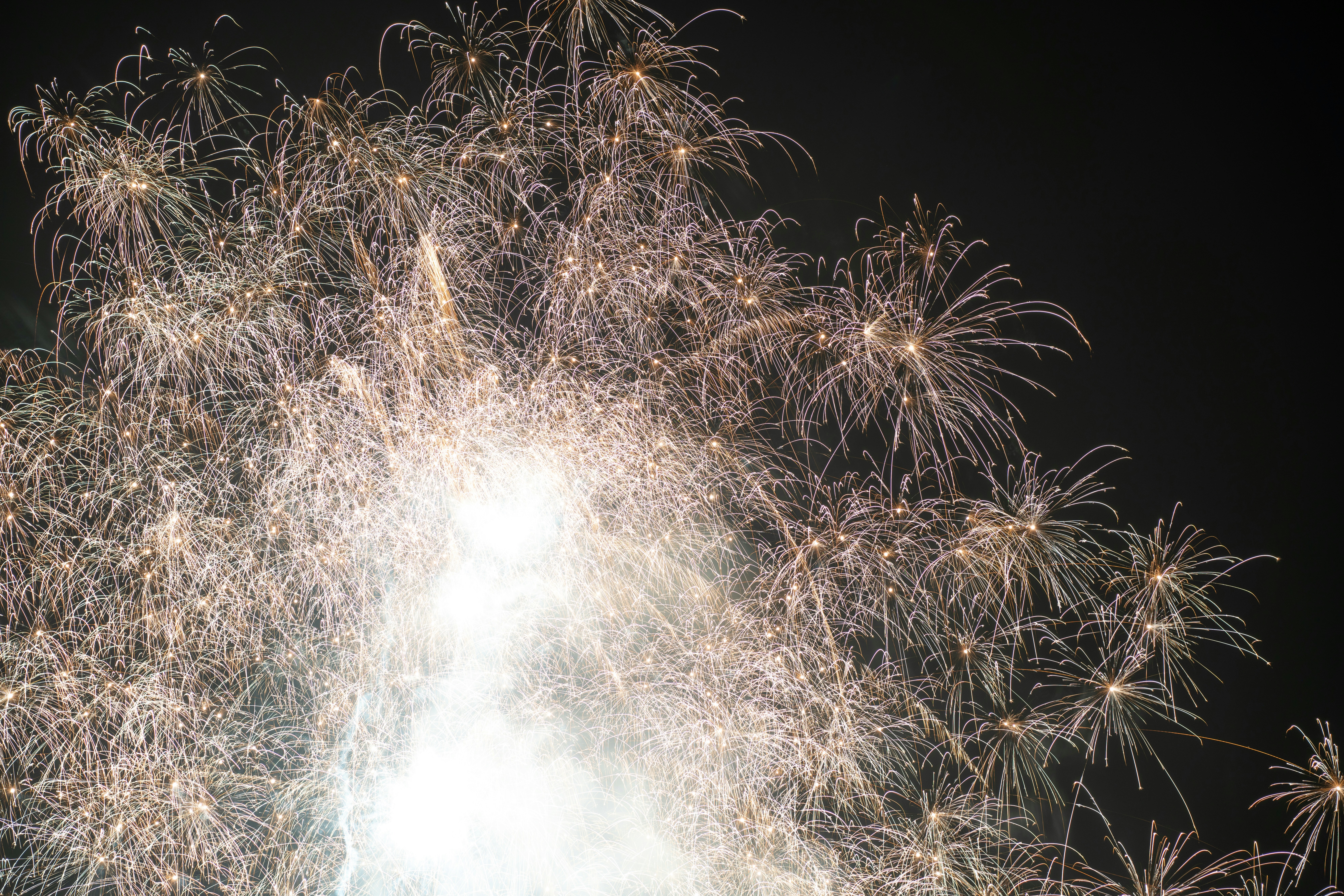 Explosive display of fireworks illuminating the night sky with intricate patterns and vibrant sparks.