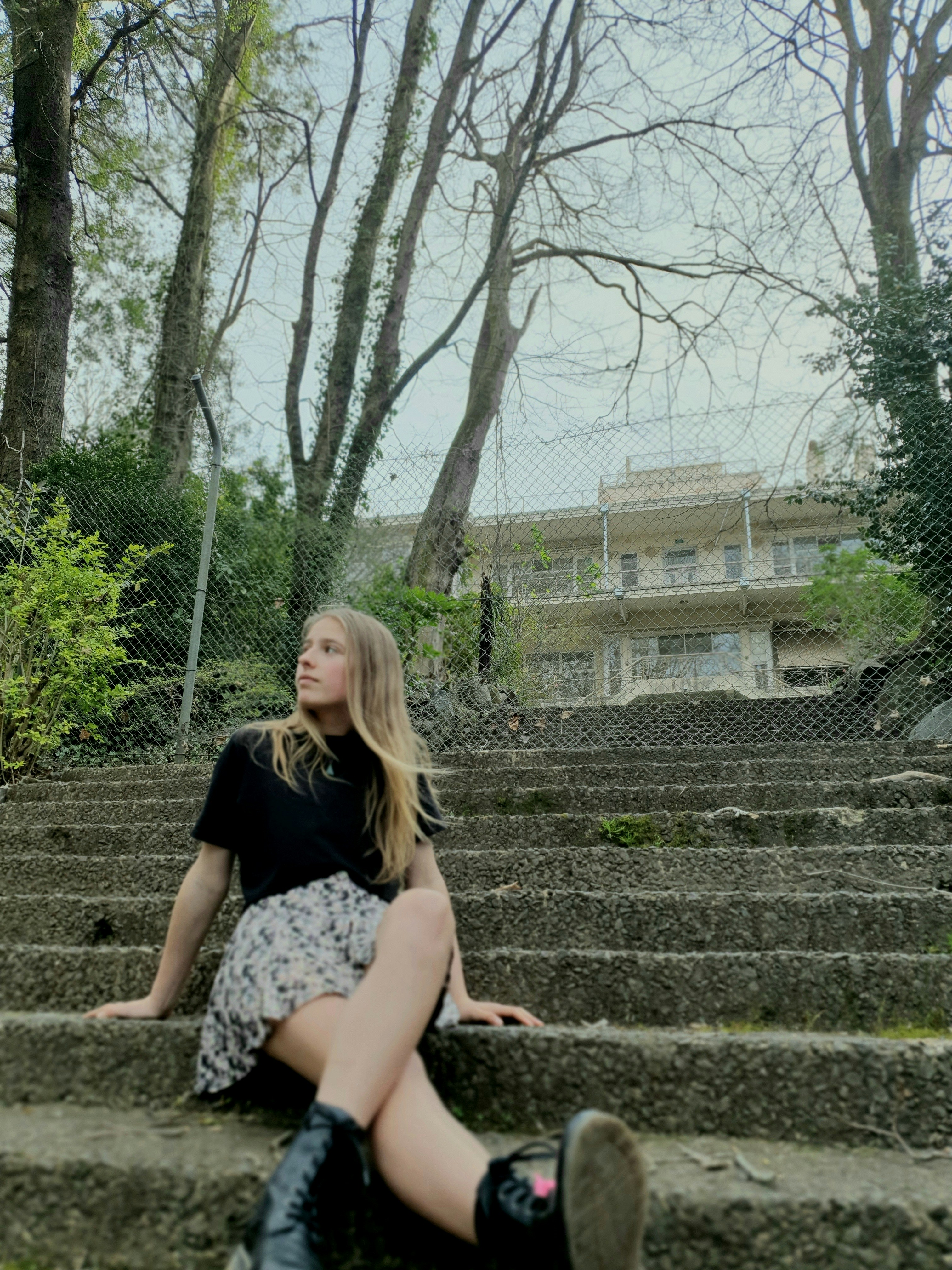 Girl sitting on stairs in front of mansion