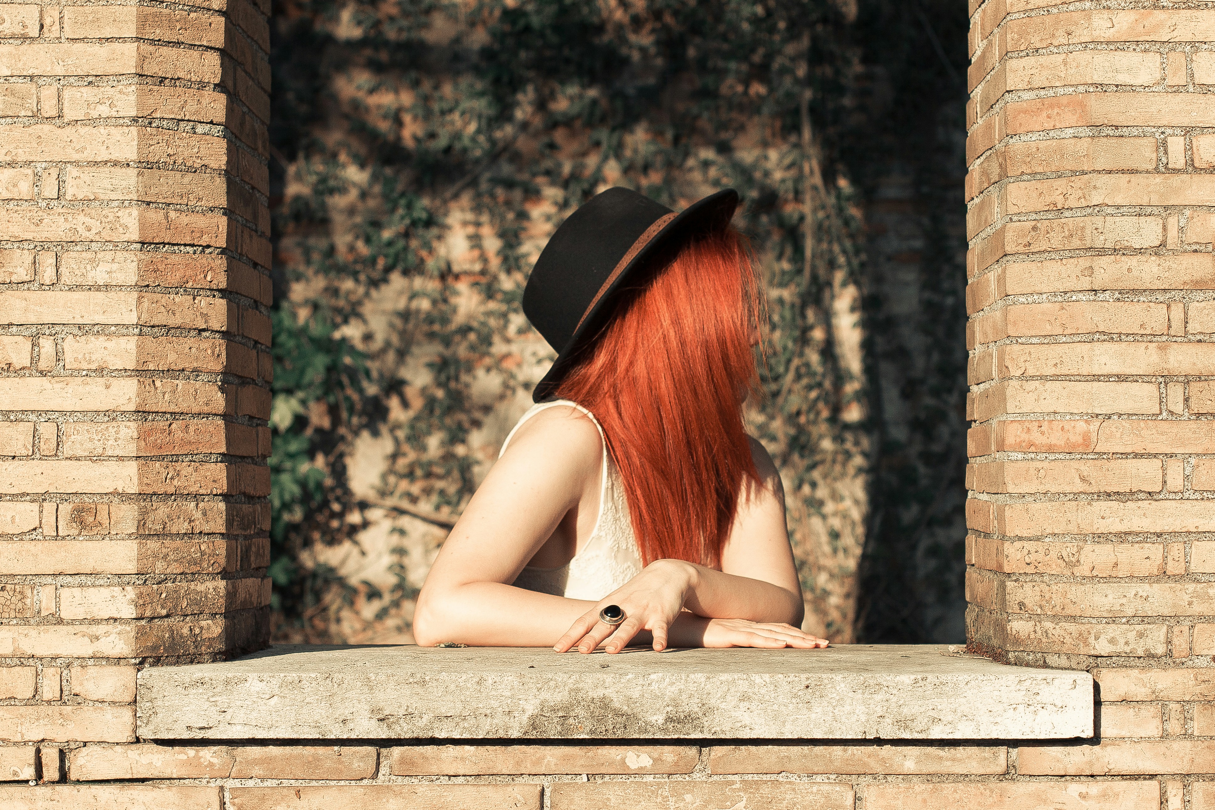 Crimson Tresses Framed by Brick Arch in Golden Hour Light
