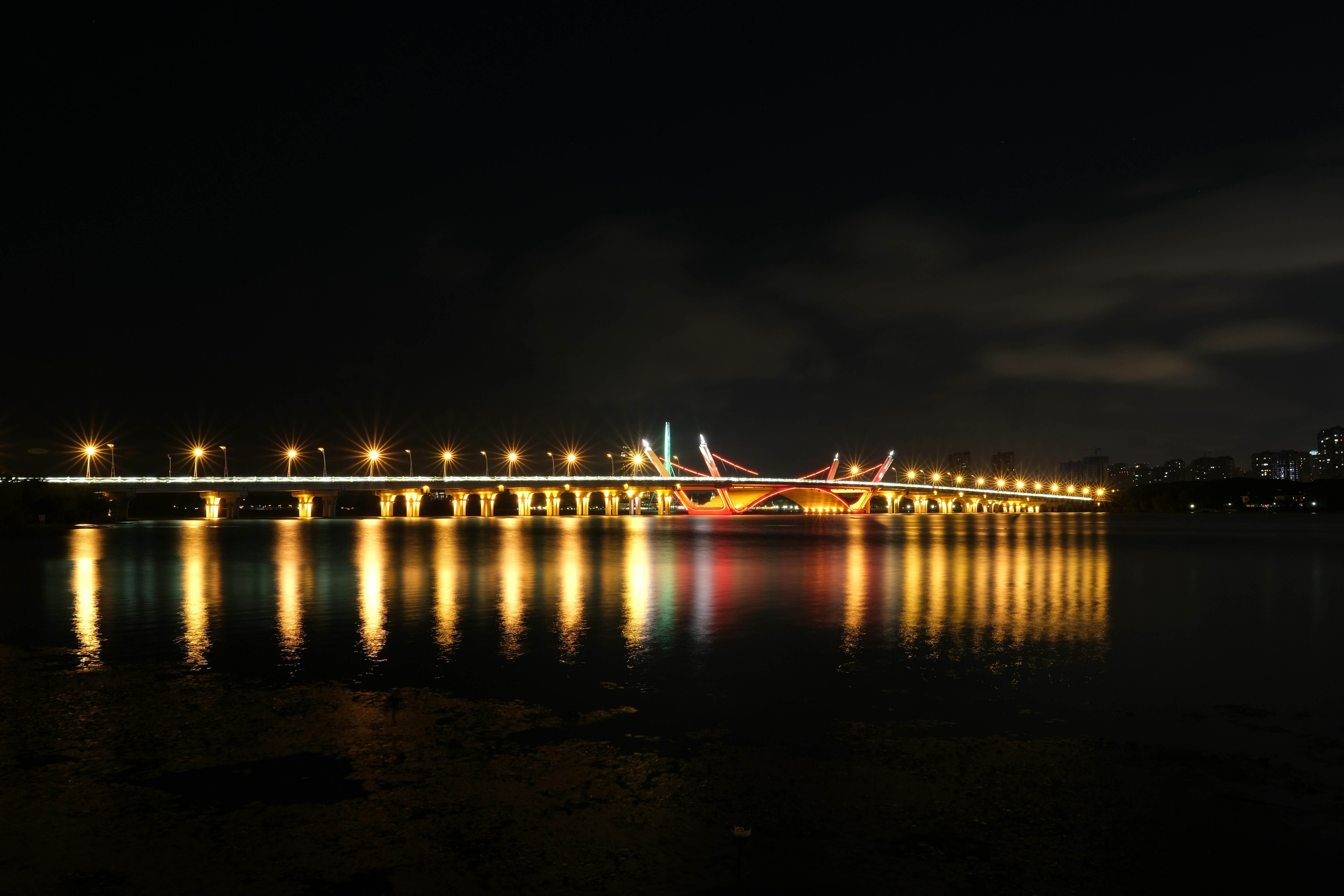 A long bridge over a body of water at night photo – Free Building Image ...