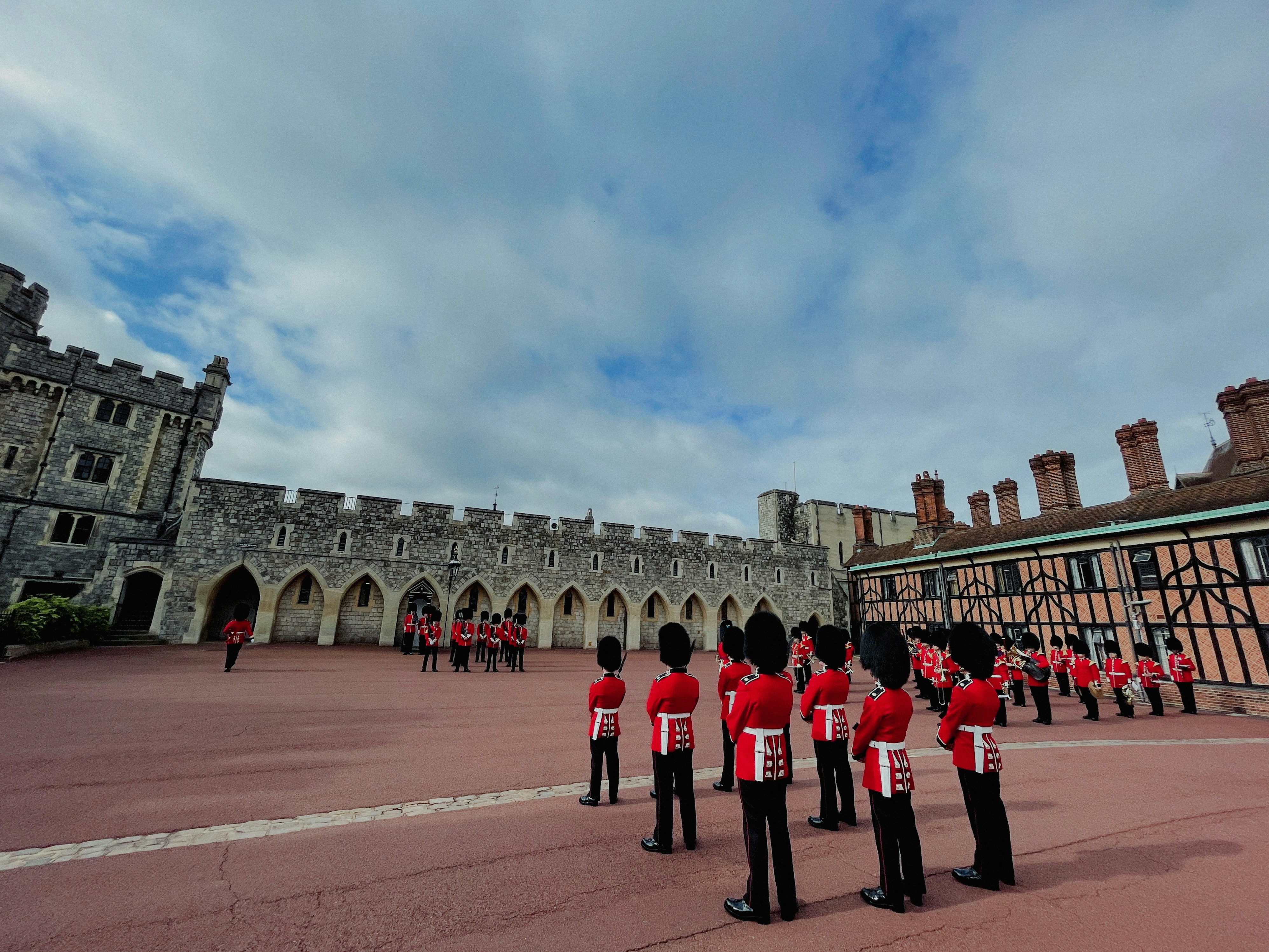 Scarlet-Uniform Parade in a Historic Stone Courtyard