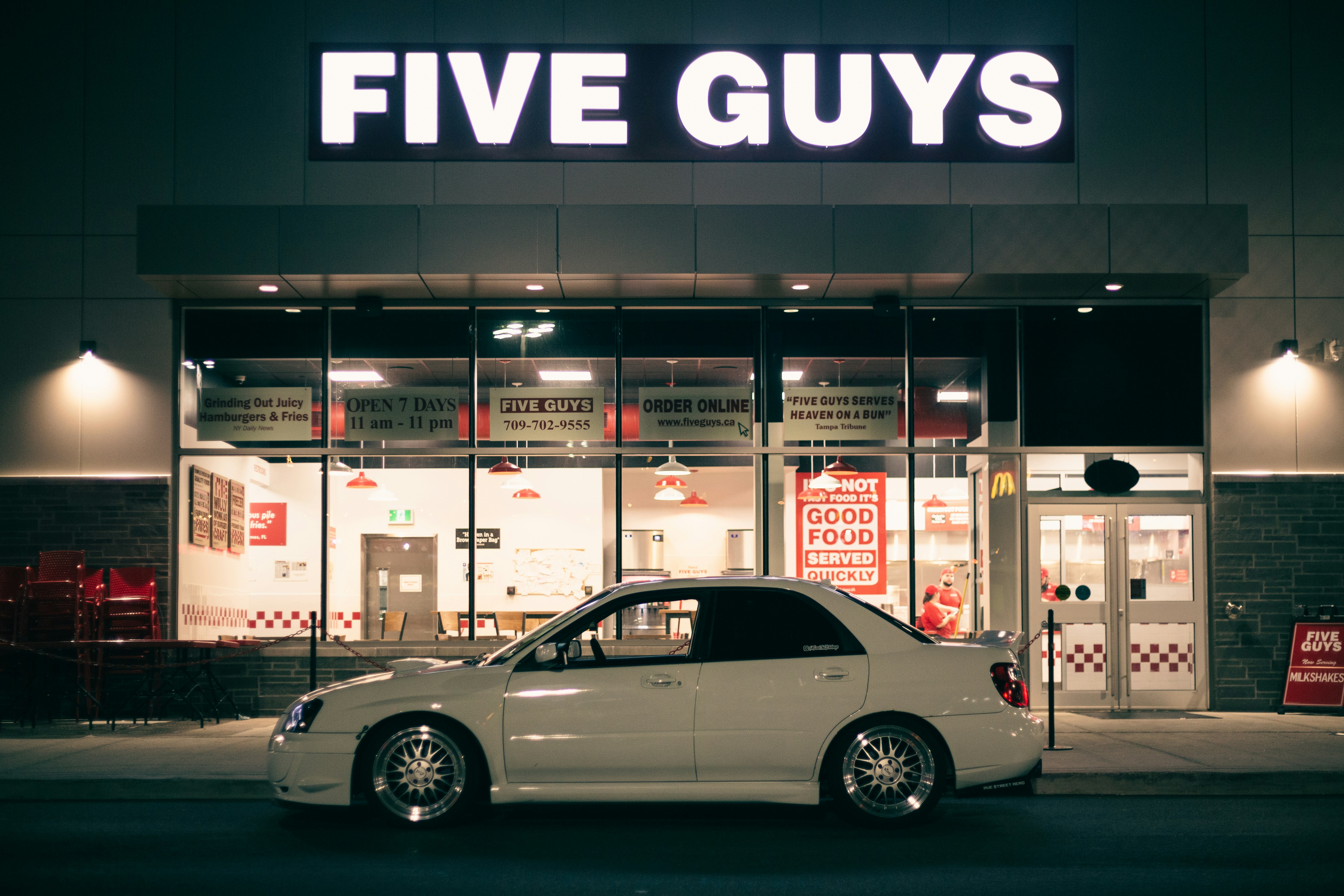 A white car parked in front of a five guys store photo – Free Tire ...