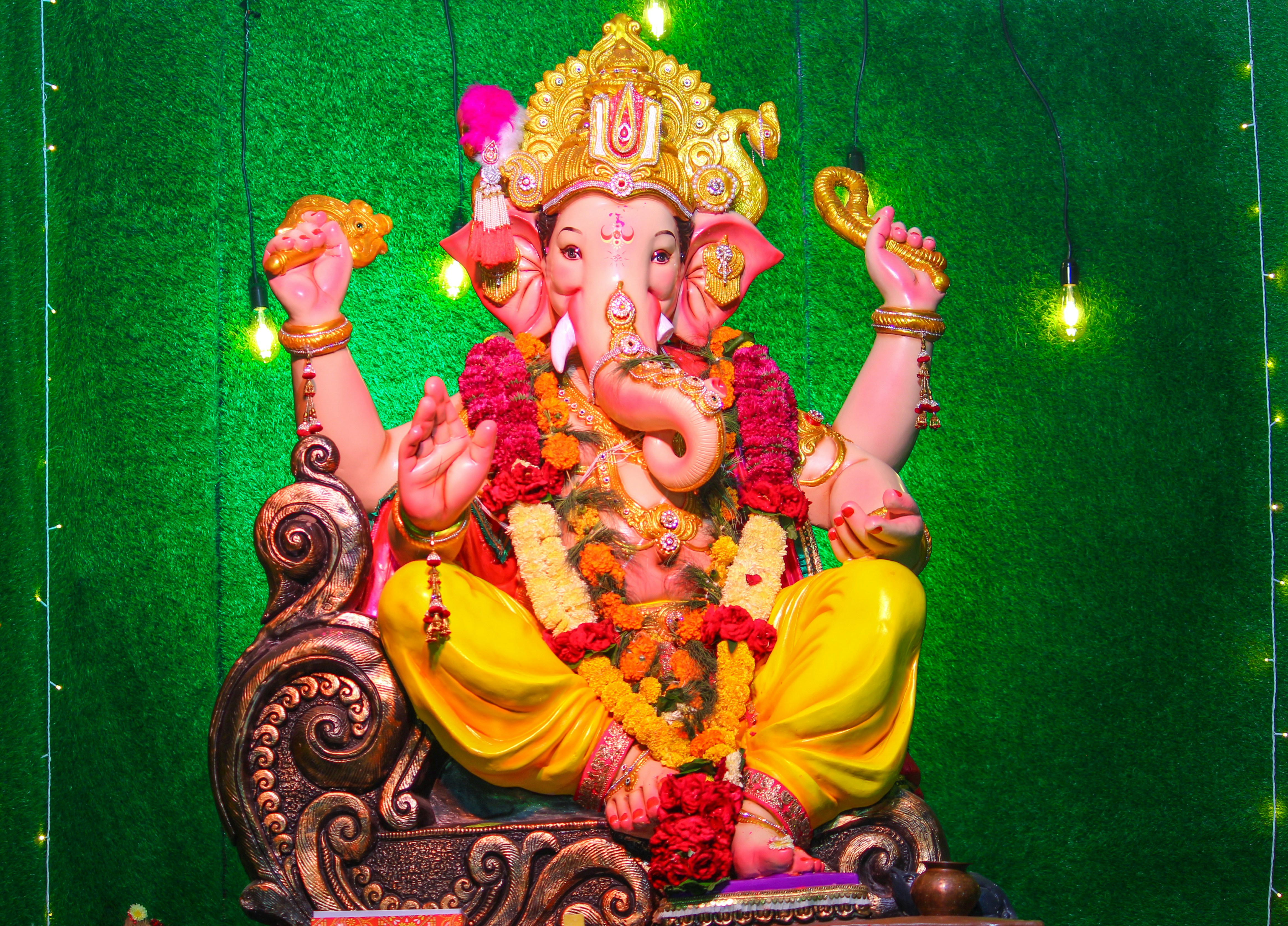 A statue of a ganesh sitting on a chair photo – Free Ganpati visarjan ...