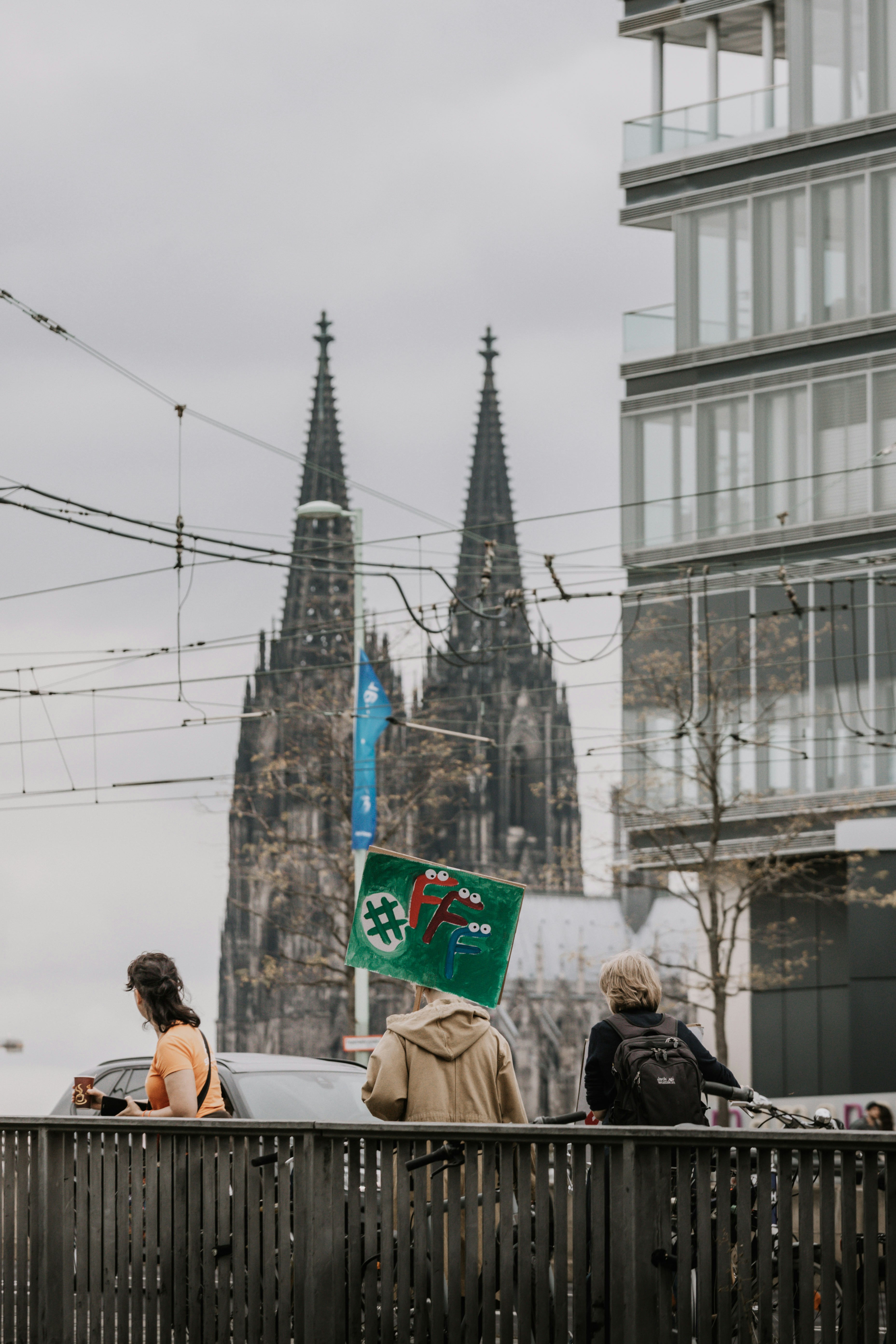 Bright Green Protest Placard Pops Against a Cityscape Framed by Twin Gothic Spires