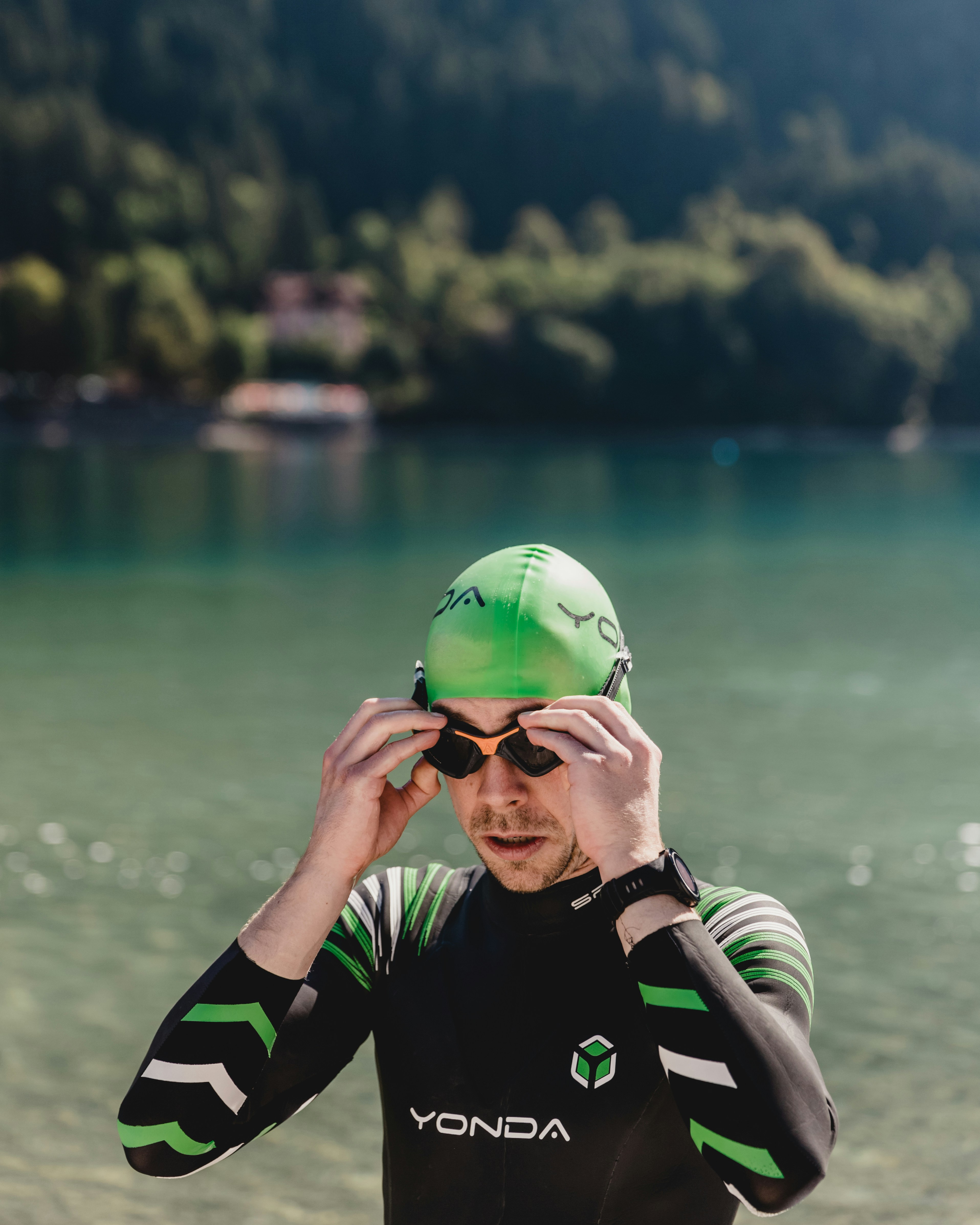 Alpine Lake Gaze: Green-Capped Swimmer Adjusting Goggles
