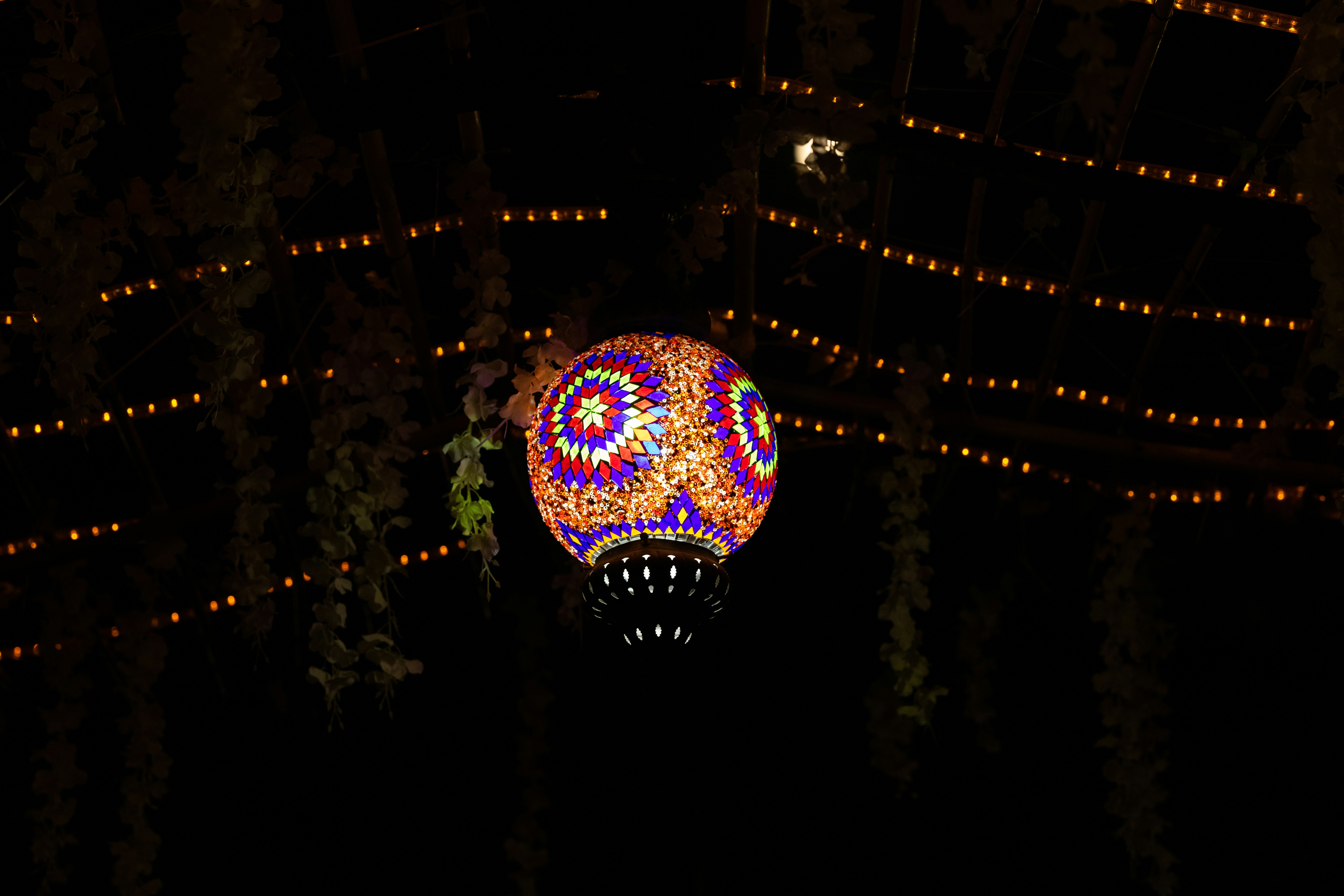 Mosaic Lantern Hovering Beneath a Canopy of Fairy Lights