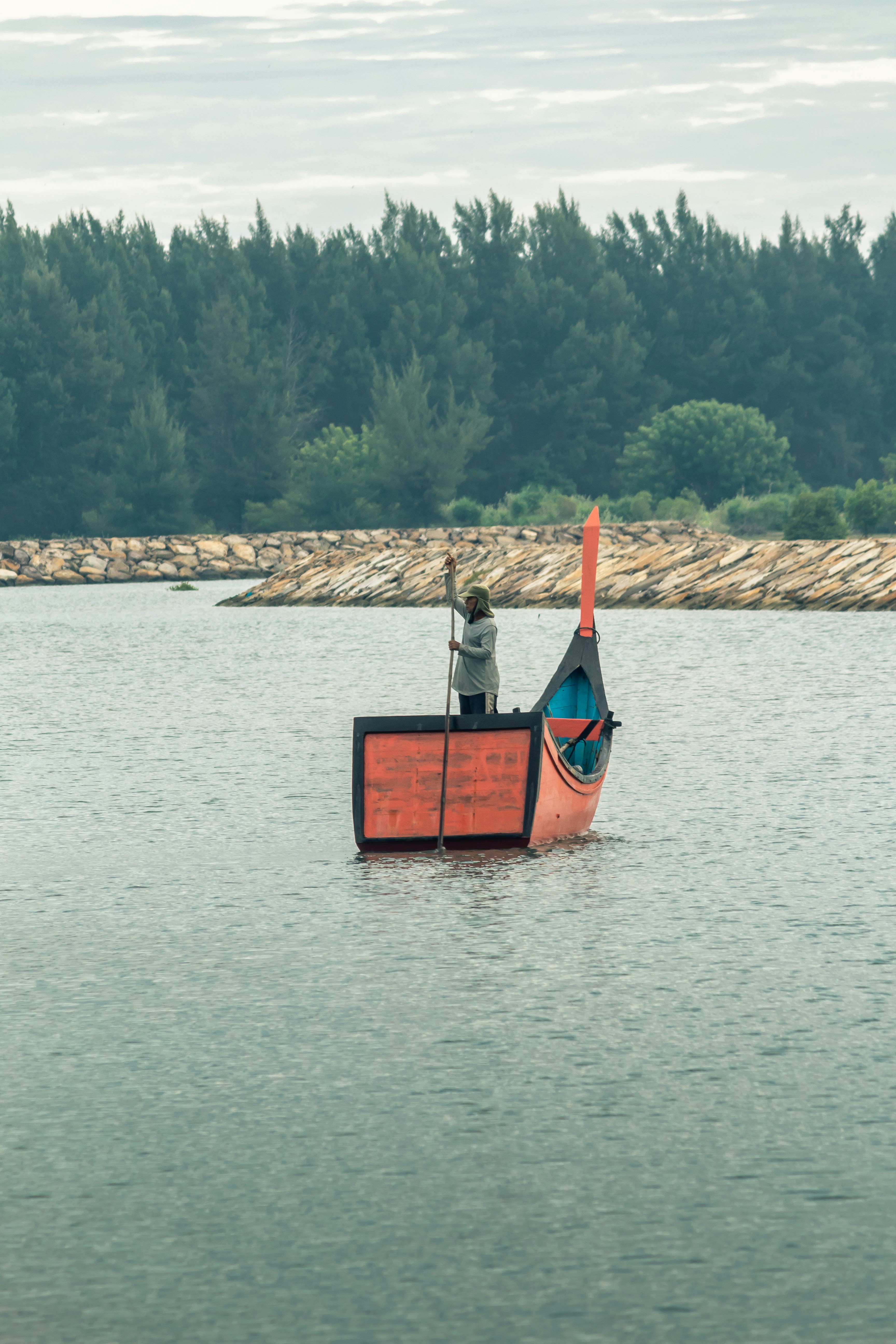 Red Boat on Quiet Lake: A Silent Figure at the Helm