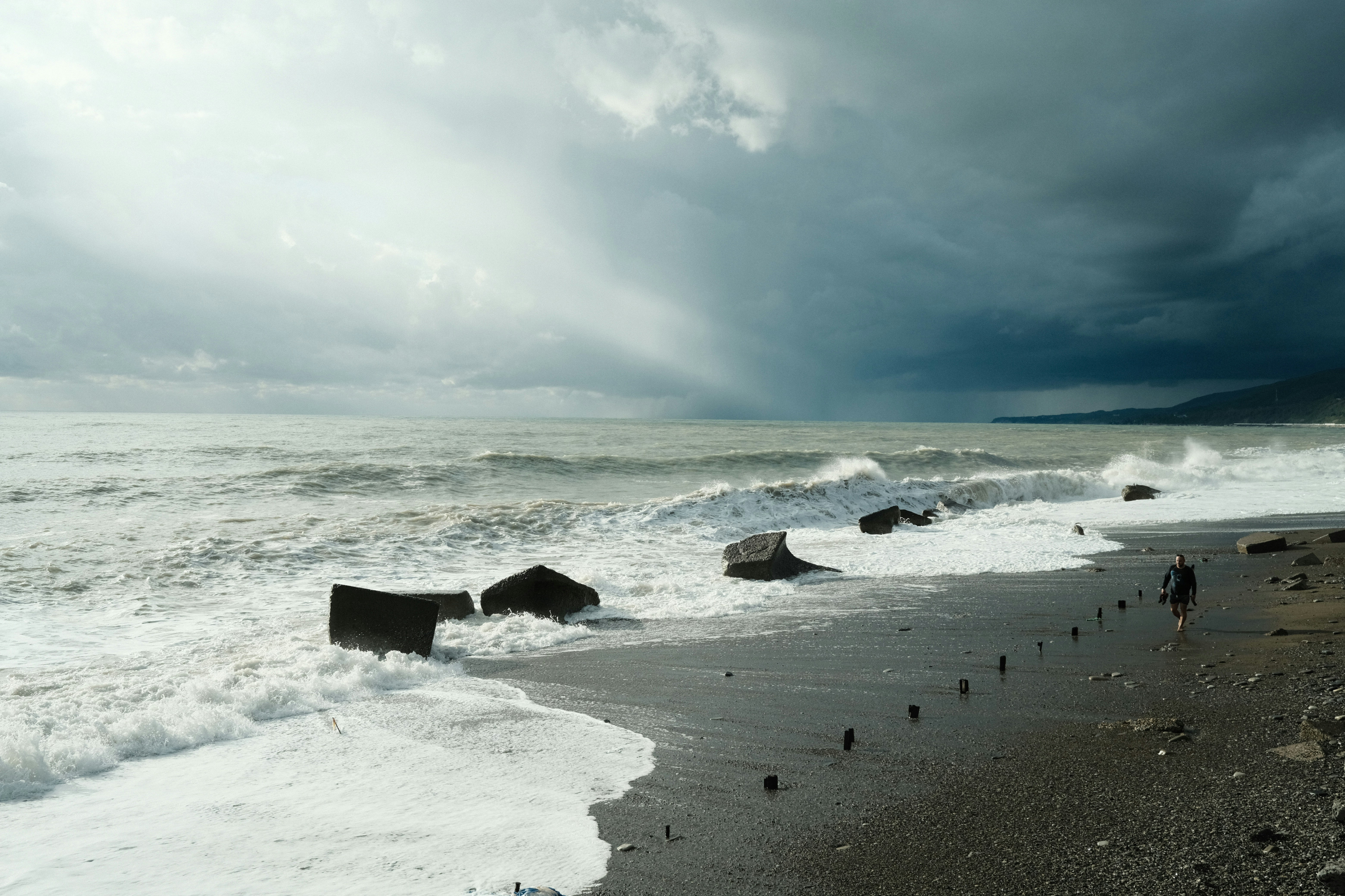 Stormy Shoreline: A Line of Breakwaters under Graying Skies