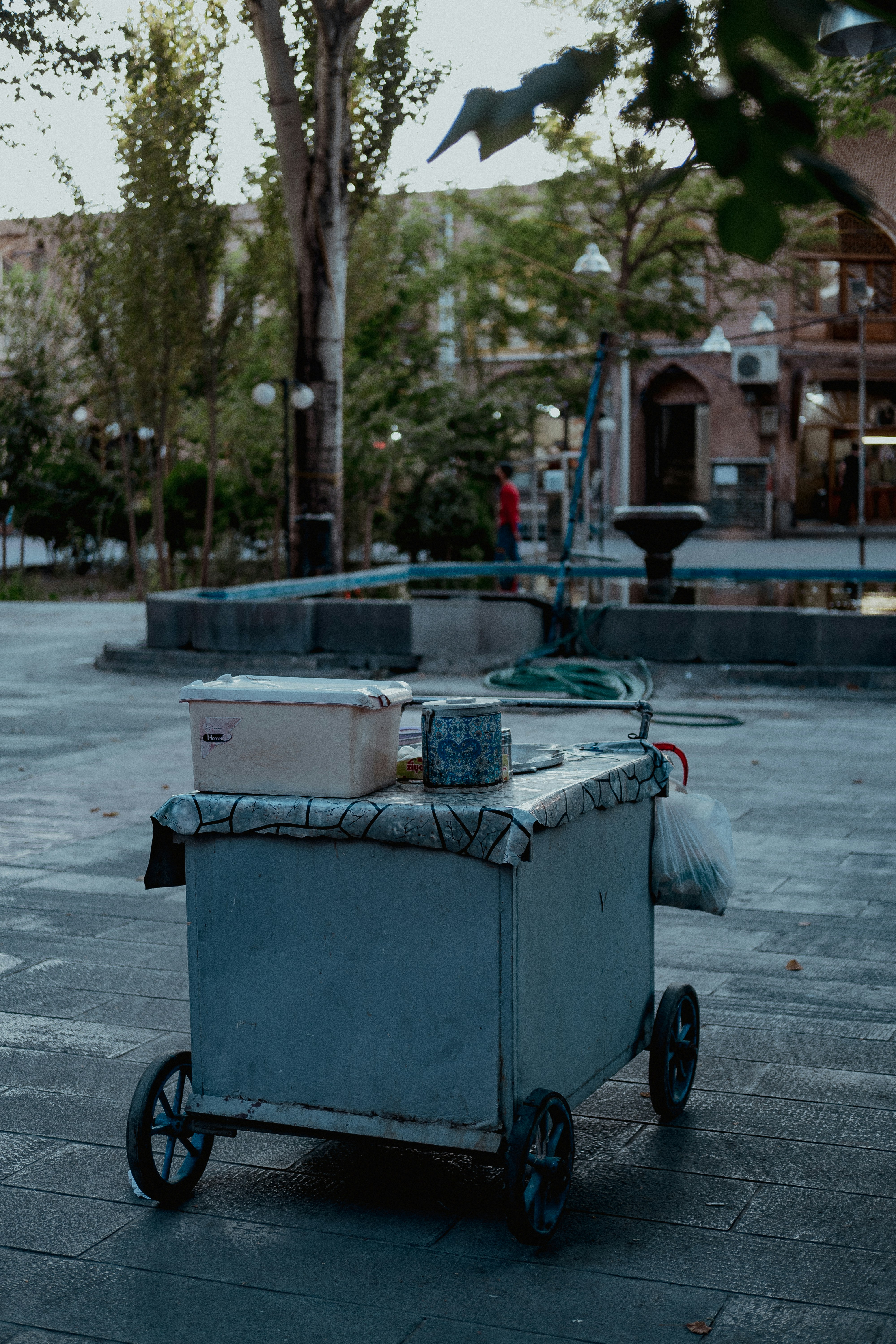 Dusk-Lit Street Cart: Weathered Vendor's Station by a Quiet Plaza