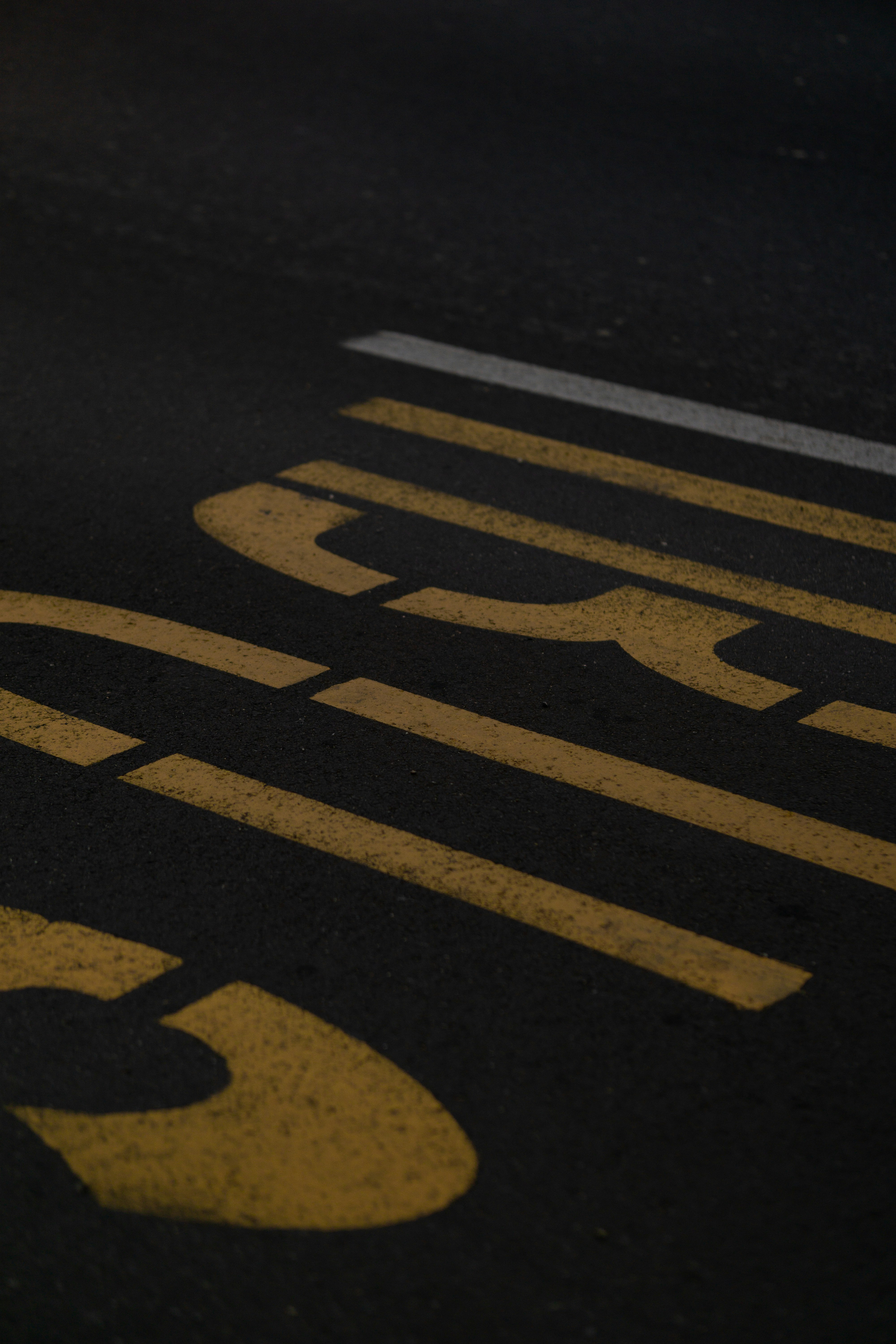 a yellow and black street sign sitting on the side of a road