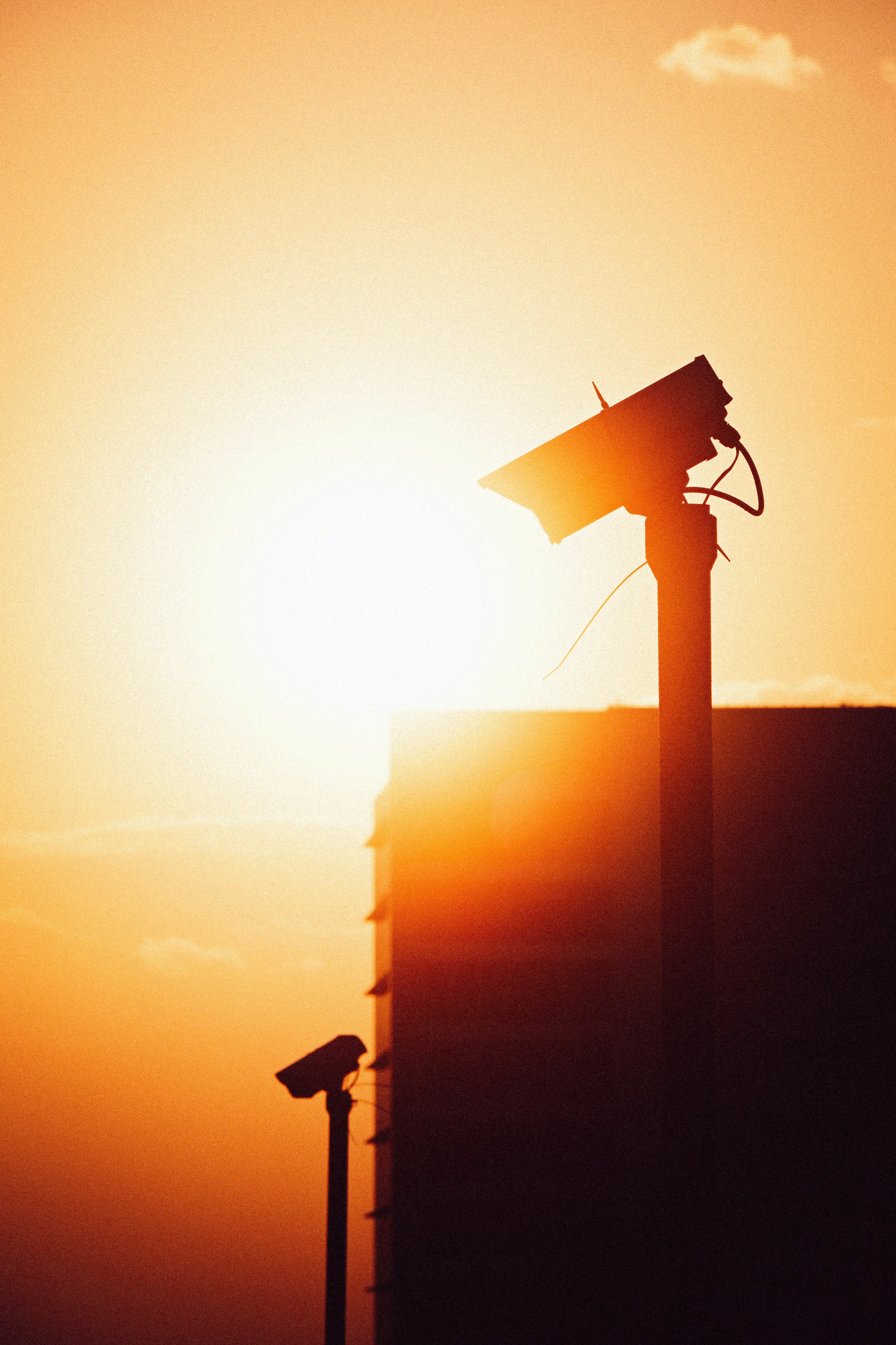 Solar Silhouette: Rooftop Antenna Against a Blazing Horizon