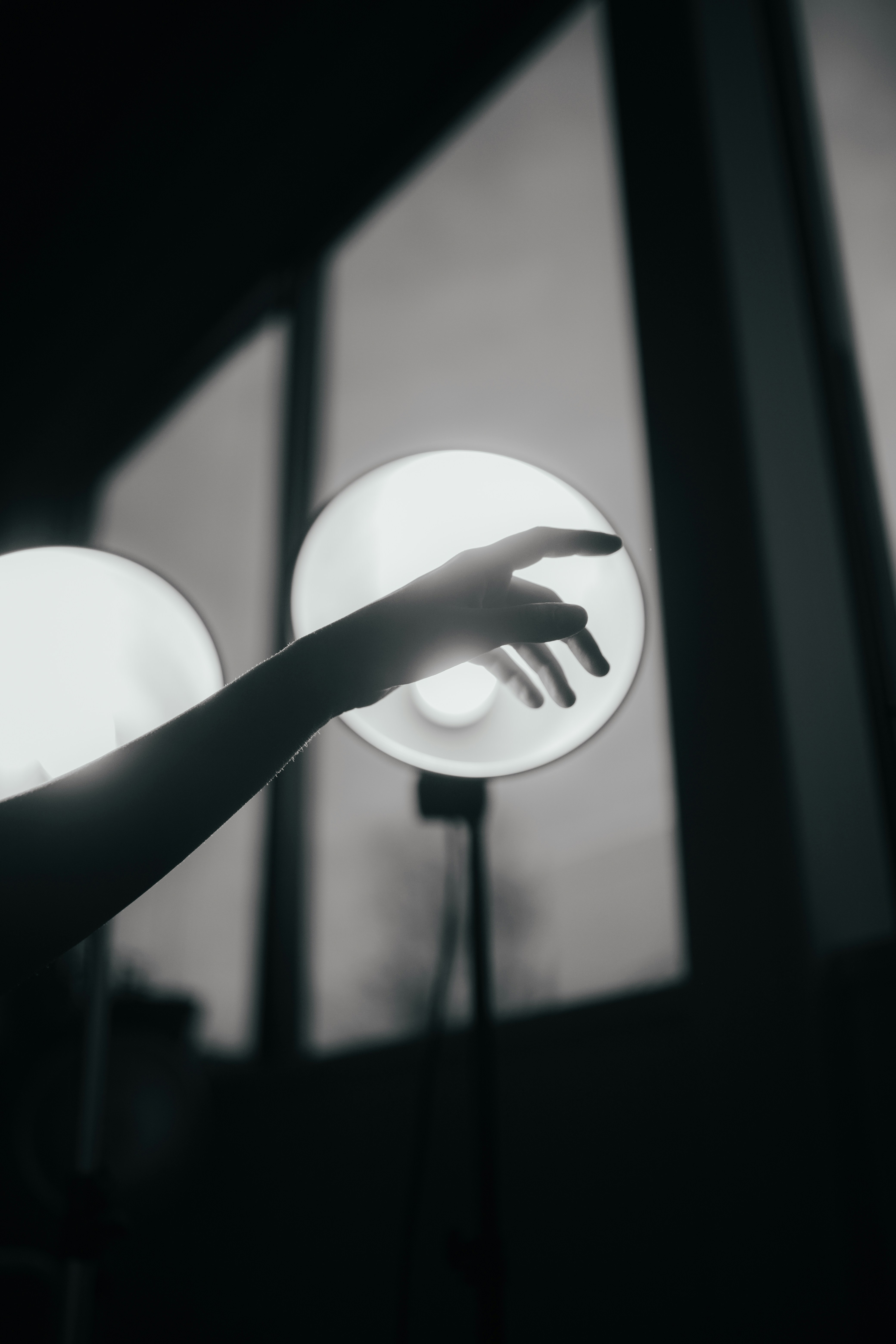 Between Circles and Gesture: Hand Reaches Toward Light Orbs in a Monochrome Studio