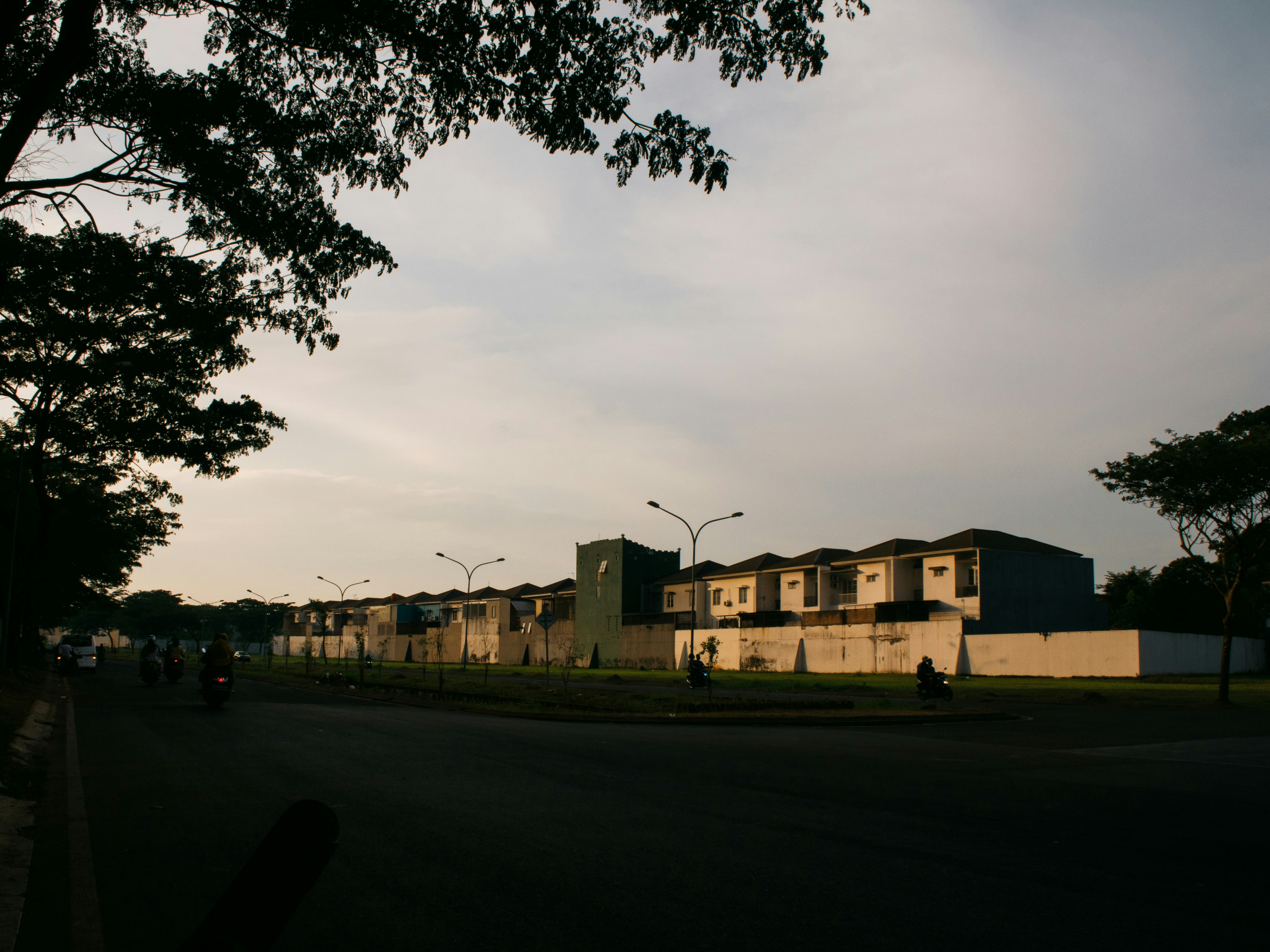 Row of houses along a quiet street under a soft evening sky.