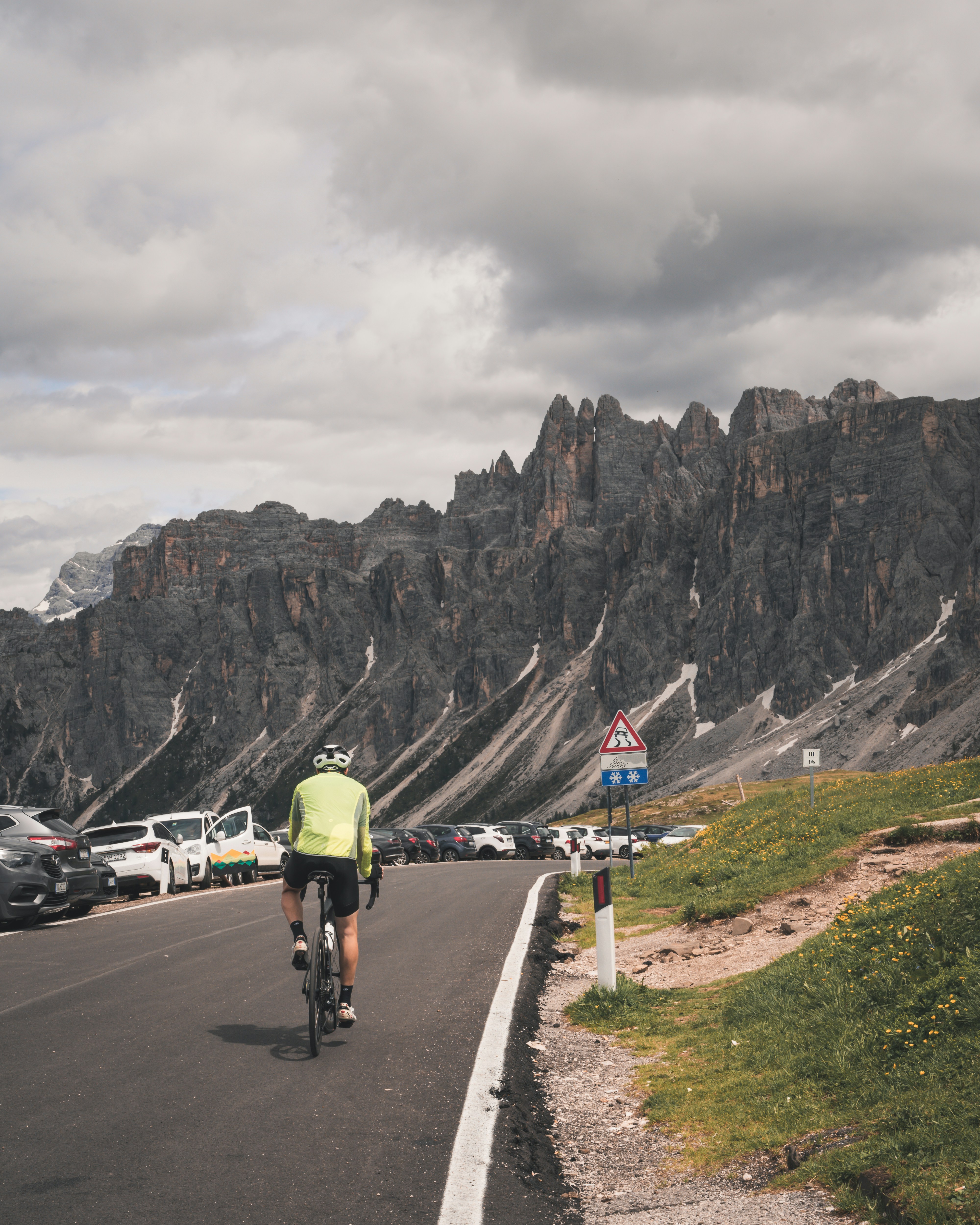 A man riding a bike down a road next to a mountain photo – Free Italia ...