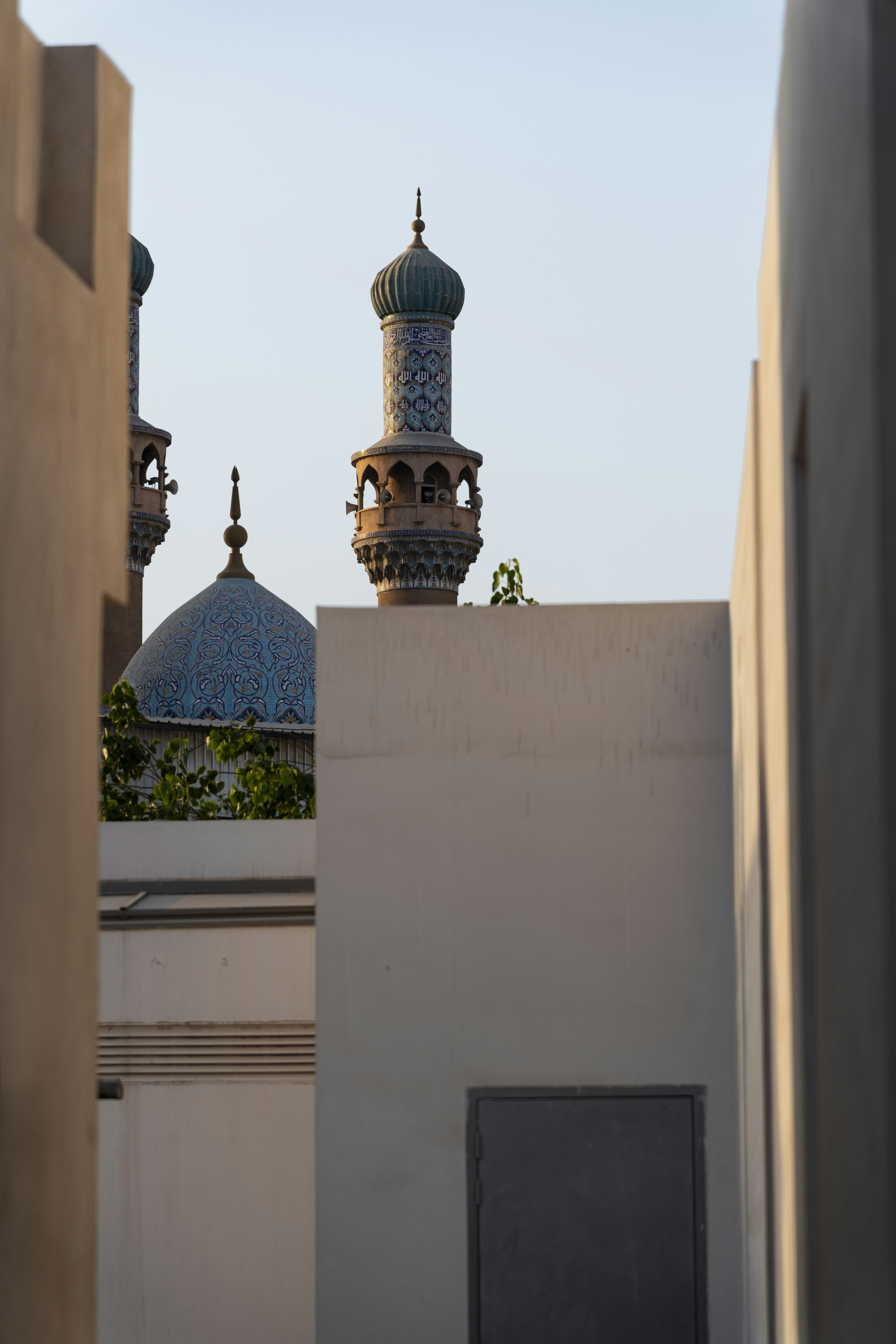 Turquoise Minaret Peeking Between Quiet White Walls