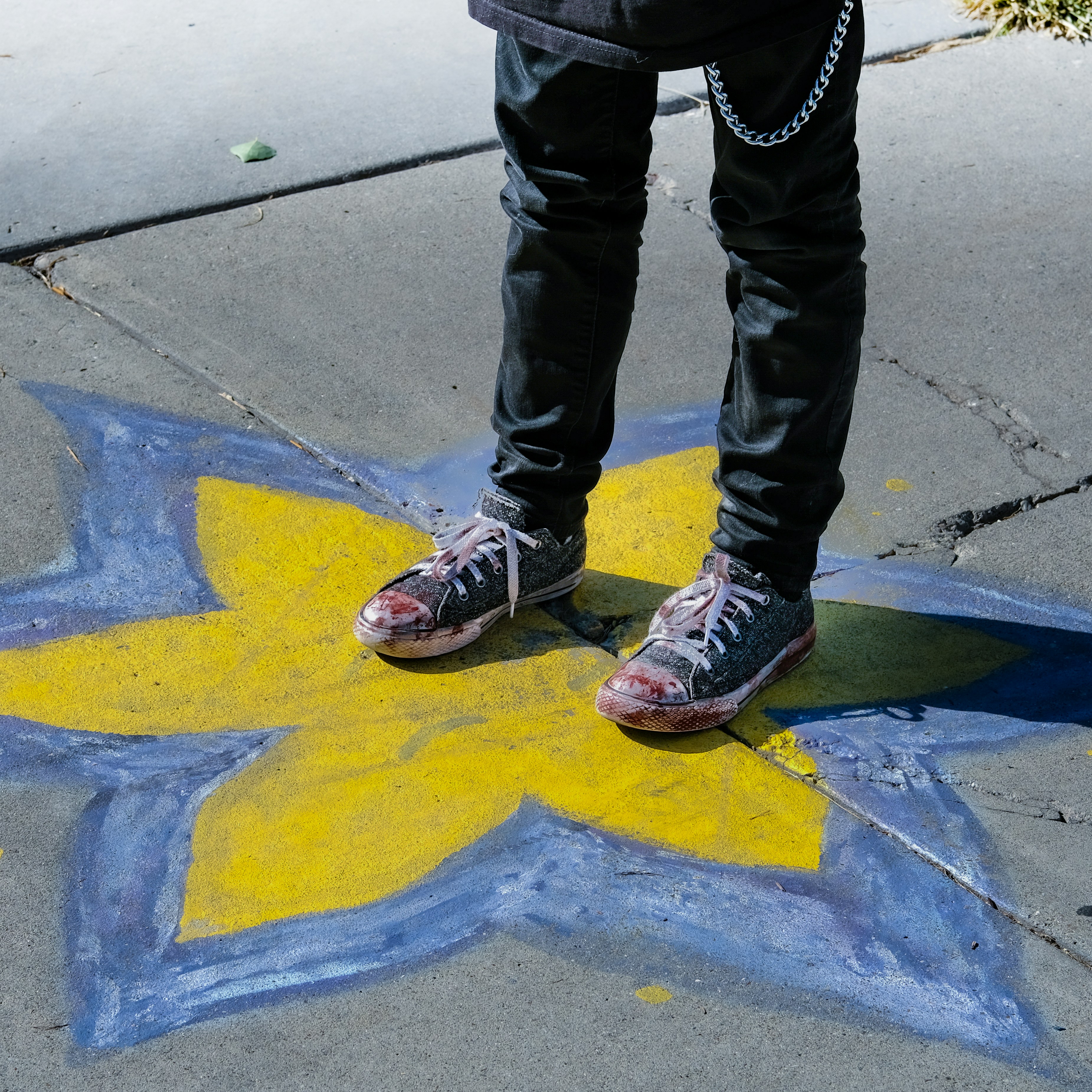 Chalk street art with an artist's shoes and pants