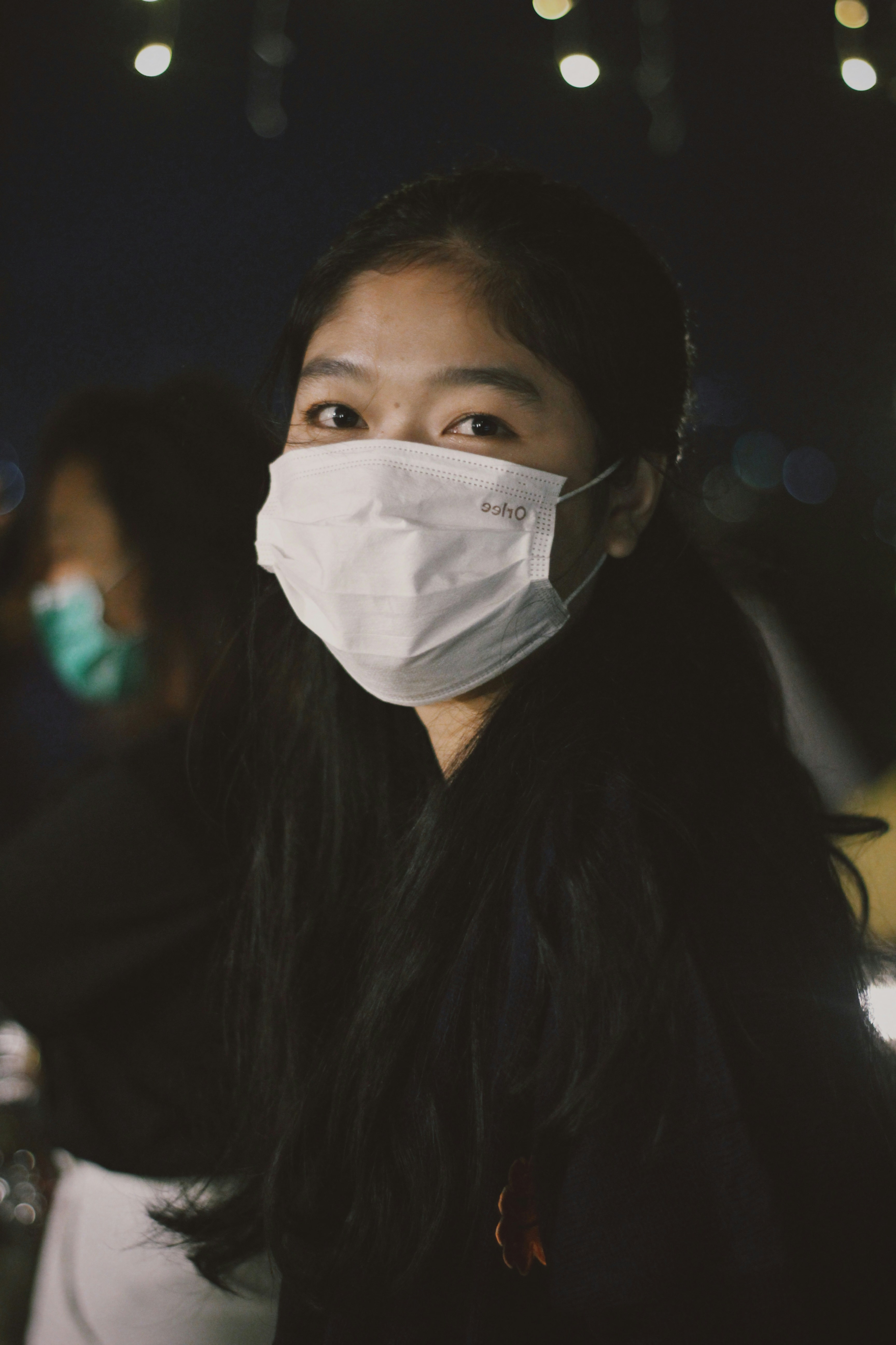 A woman wearing a face mask at night photo – Free China girl Image on ...