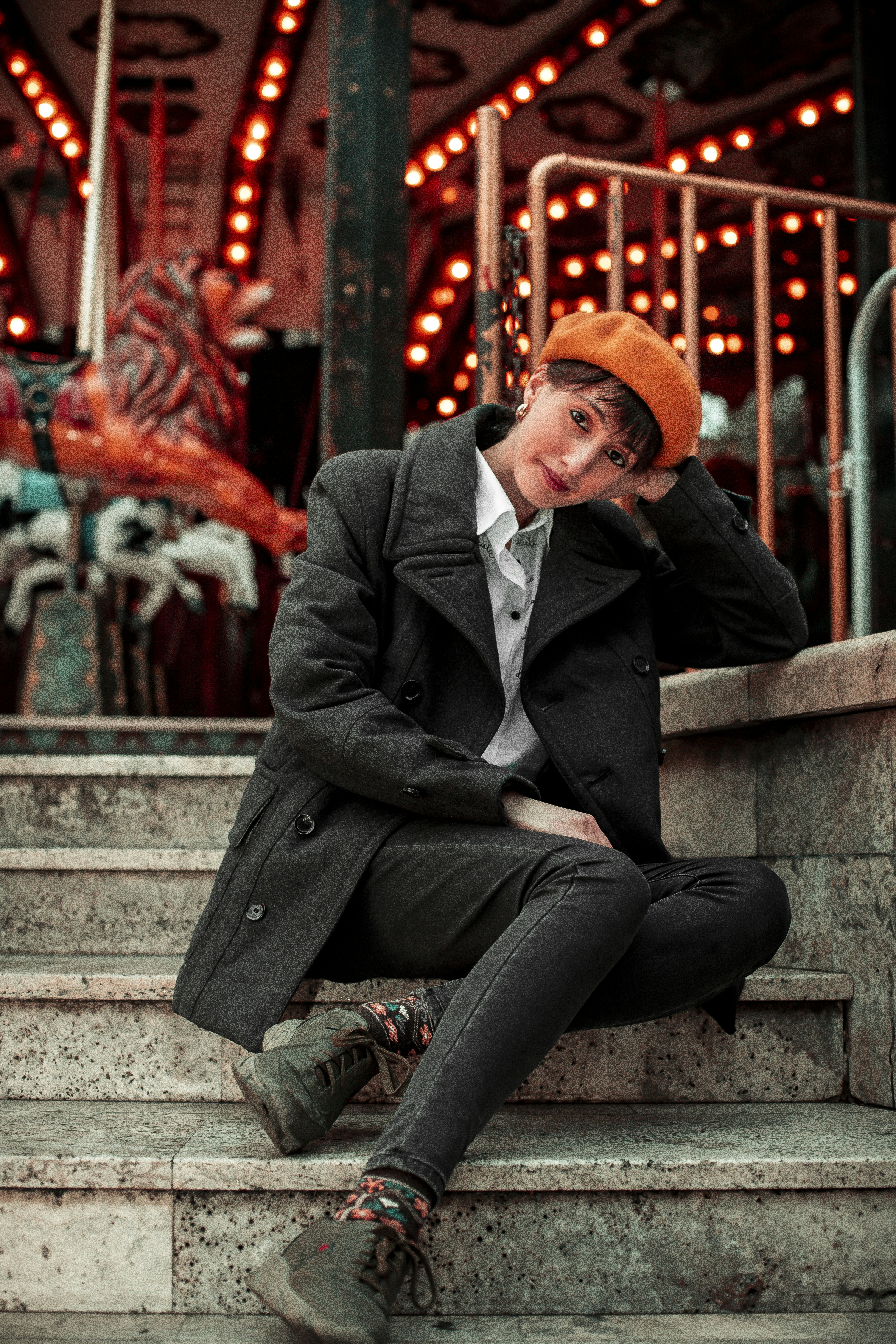 A young man sitting on the steps of a carousel photo – Free Girl ...