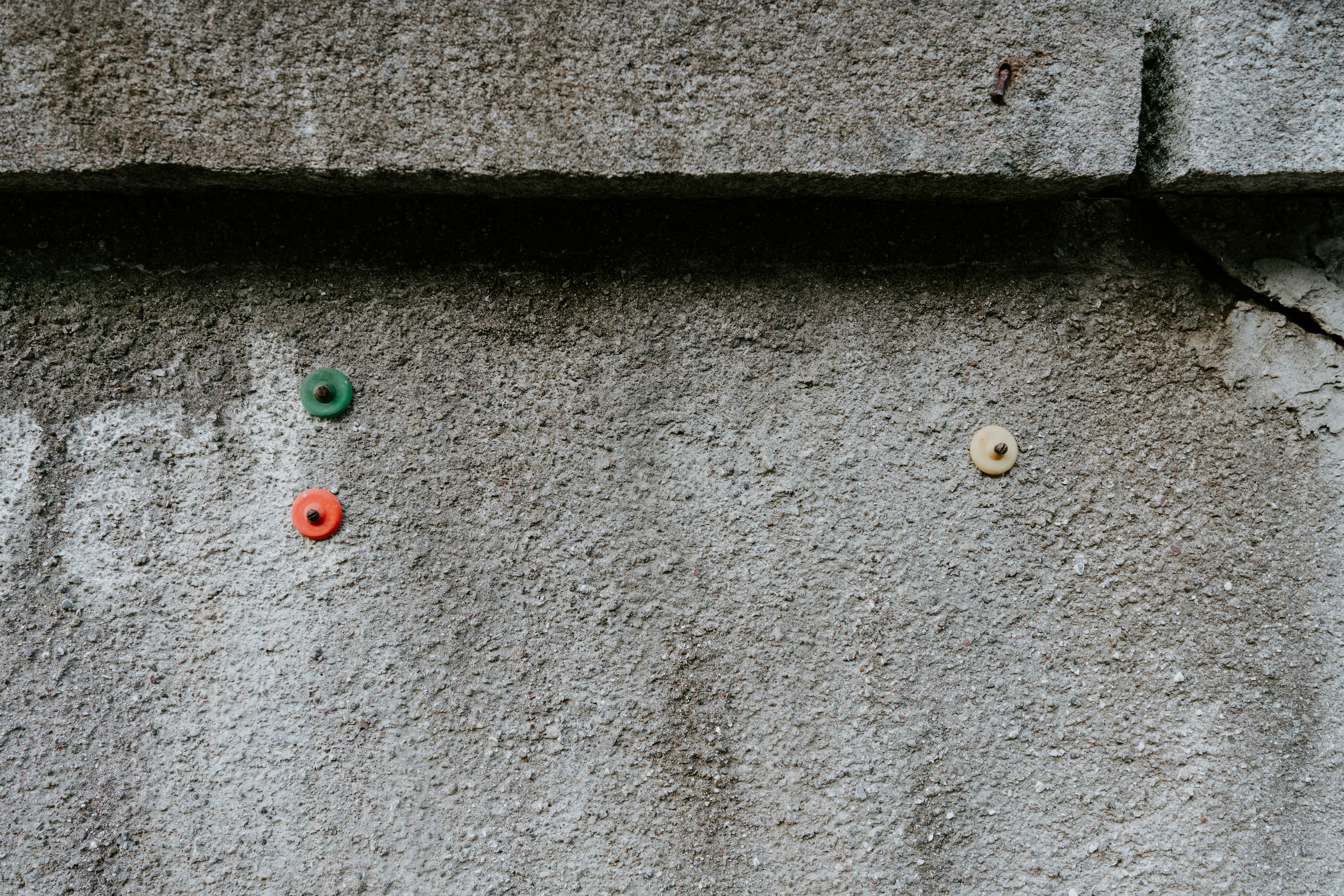 a wall with three different colored buttons on it