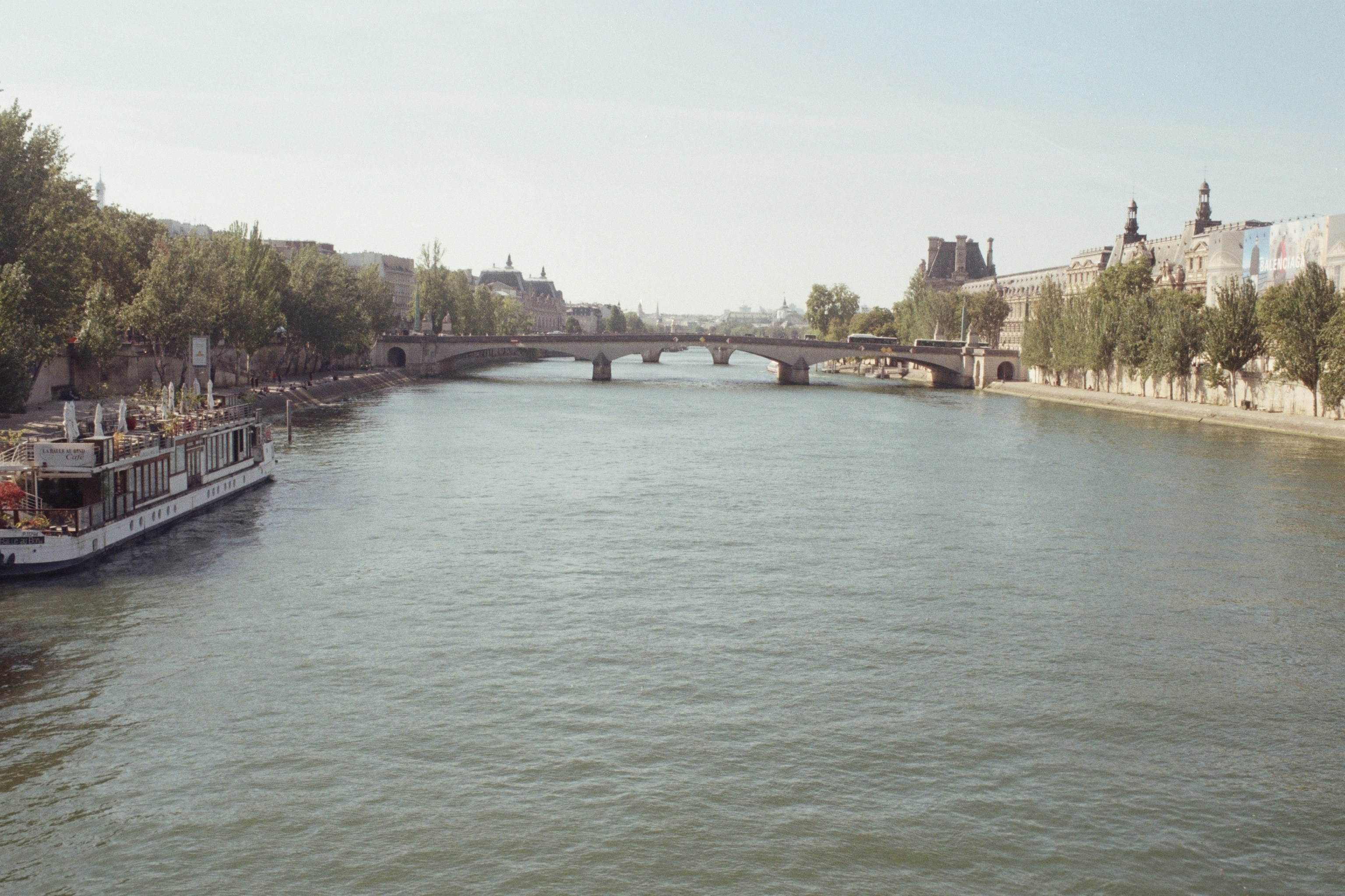 A boat traveling down a river next to a bridge photo – Free Paris Image ...