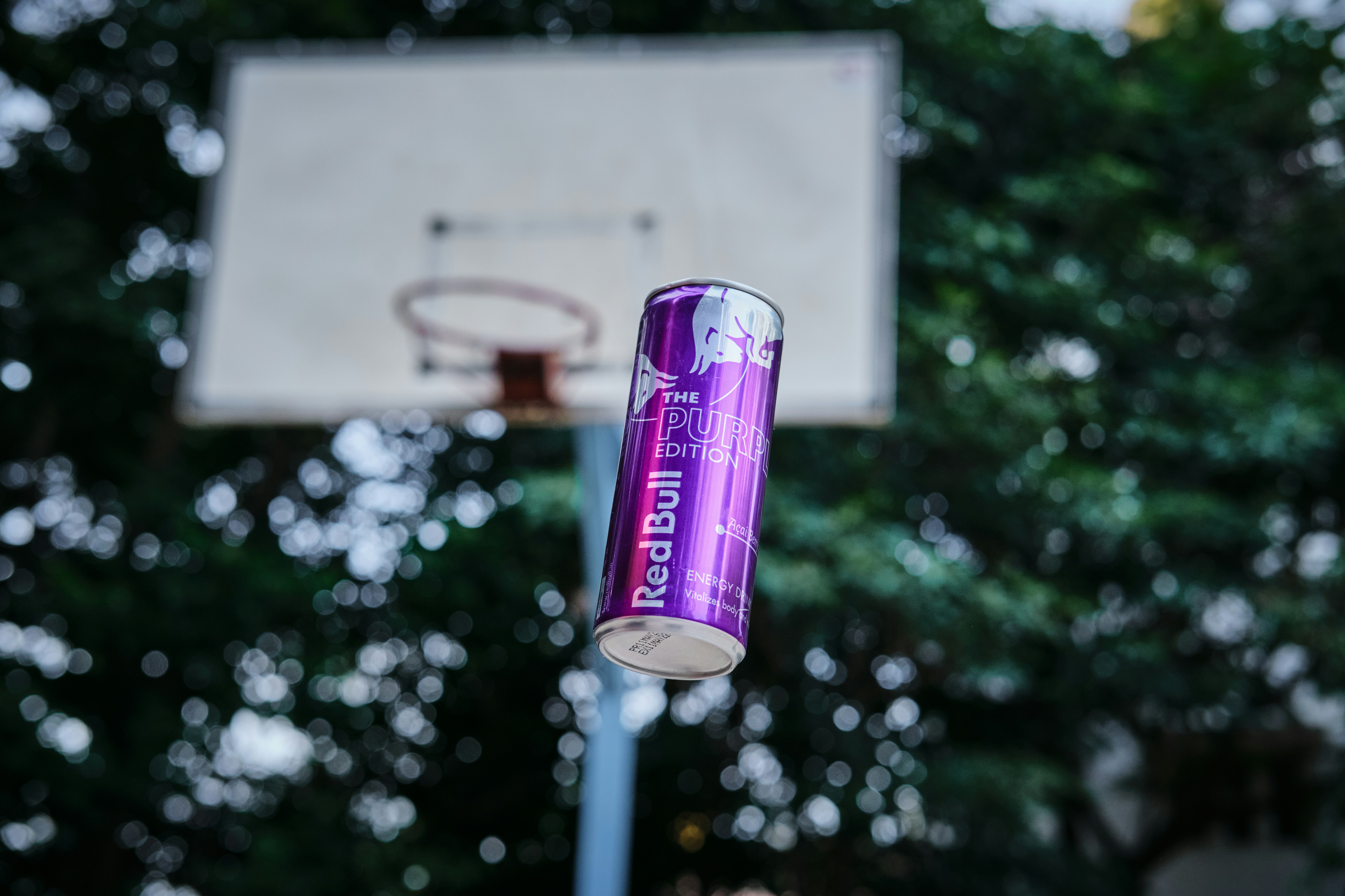 Midair Lift: Red Bull Suspended Over an Outdoor Basketball Hoop