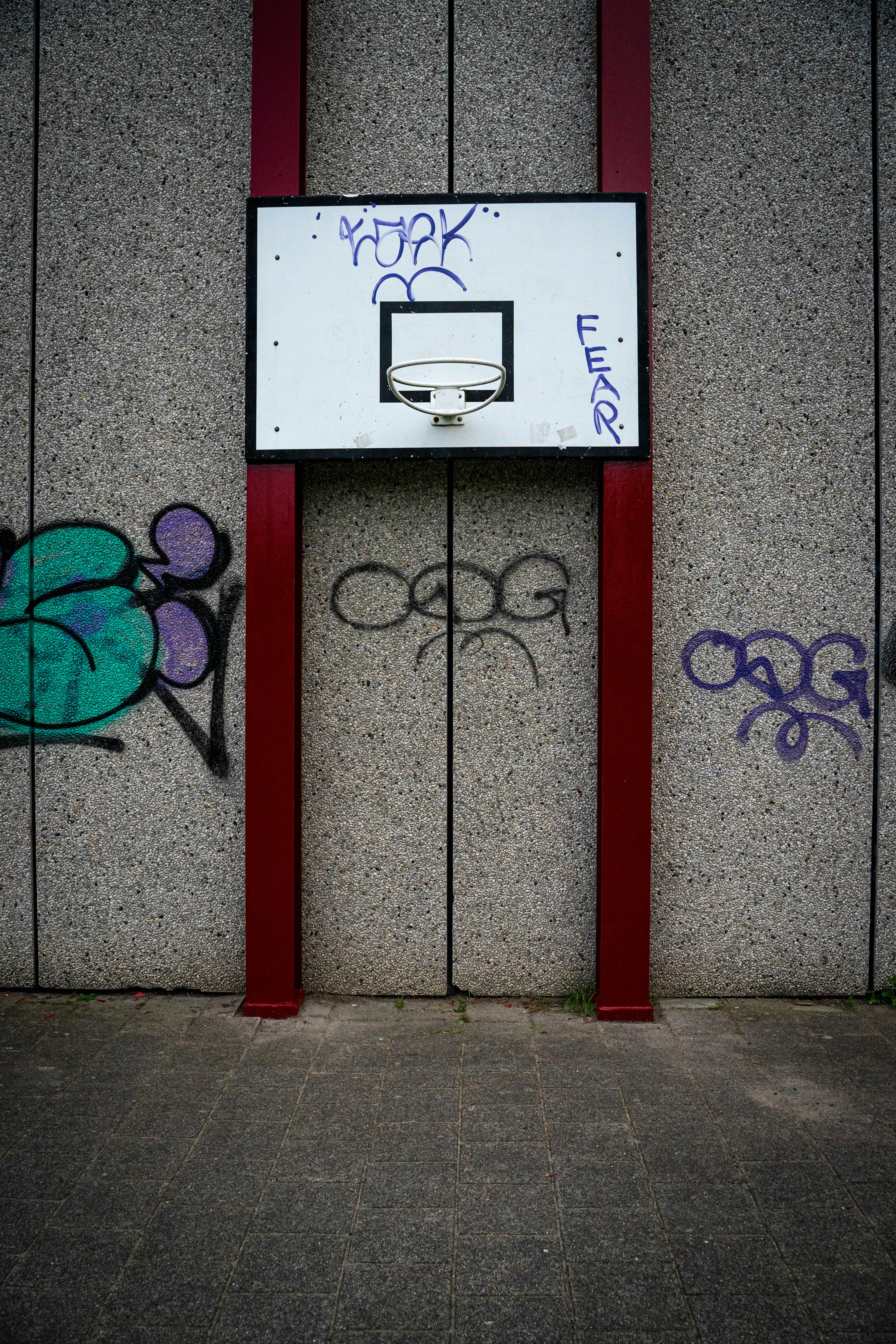 Graffiti Hoop: Urban Wall and Backboard Framed by Red Struts