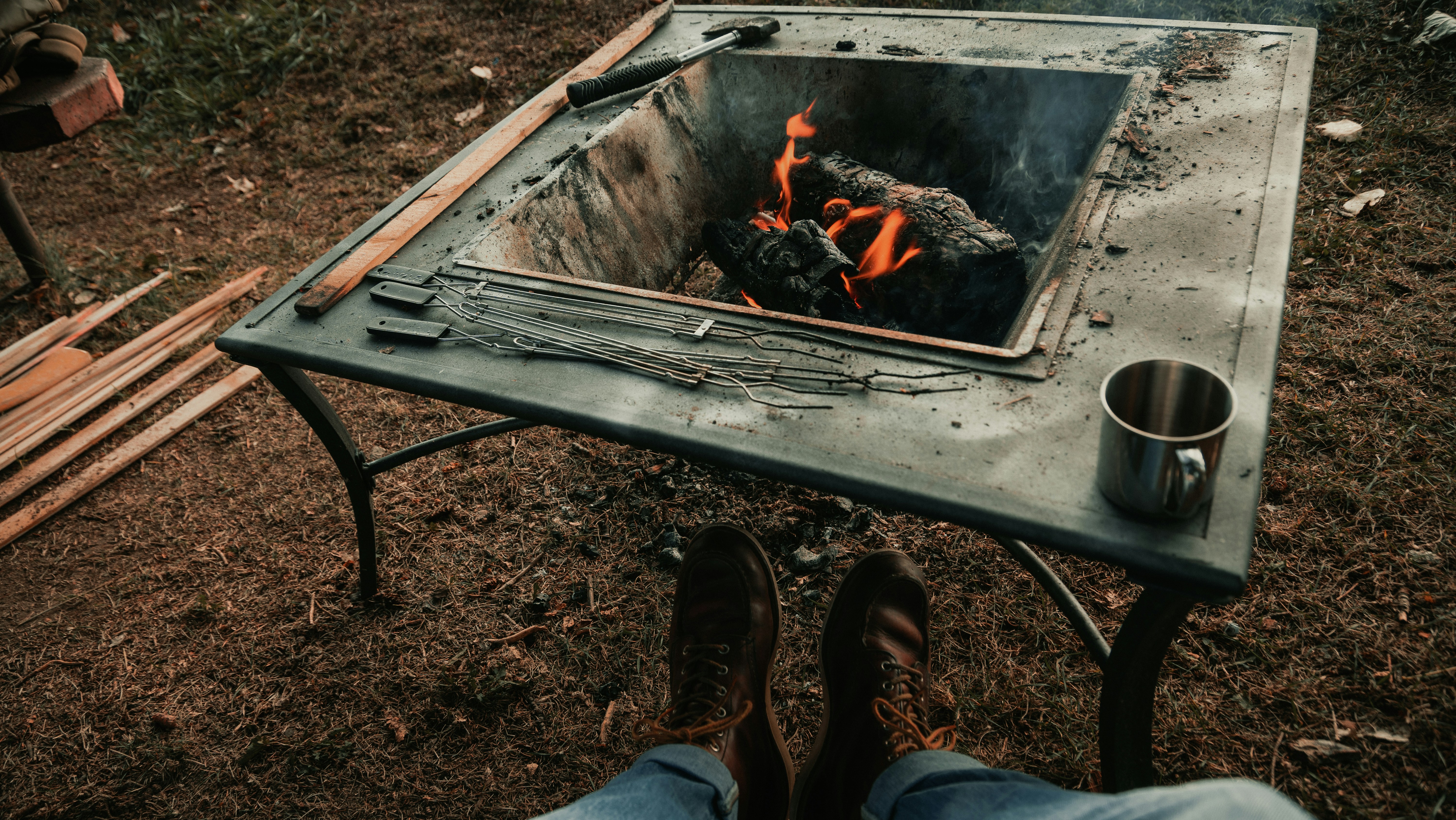 Ember Table: Boots Rest Beneath a Flickering Campfire