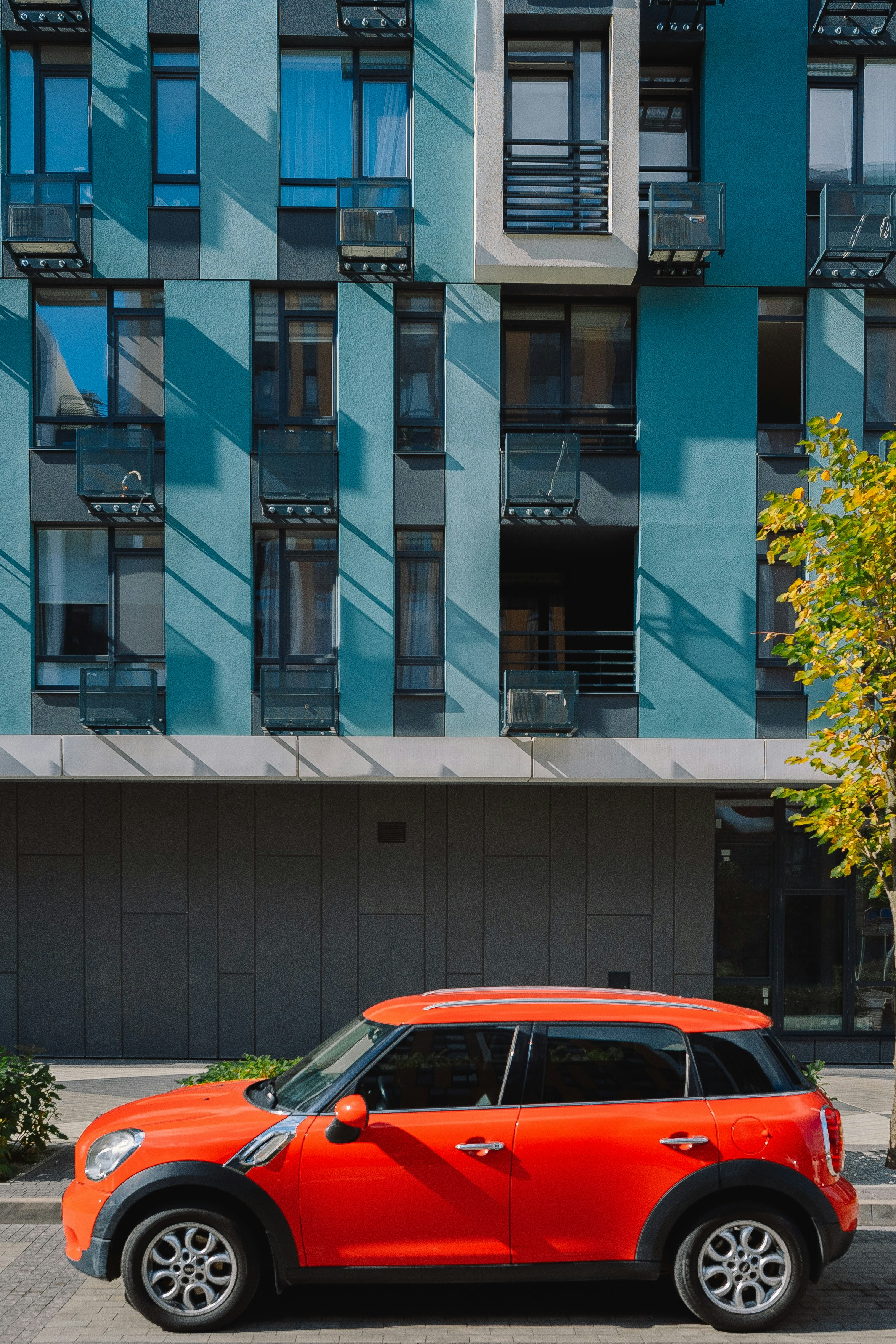 A red minivan parked in front of a building photo – Free Car Image on ...