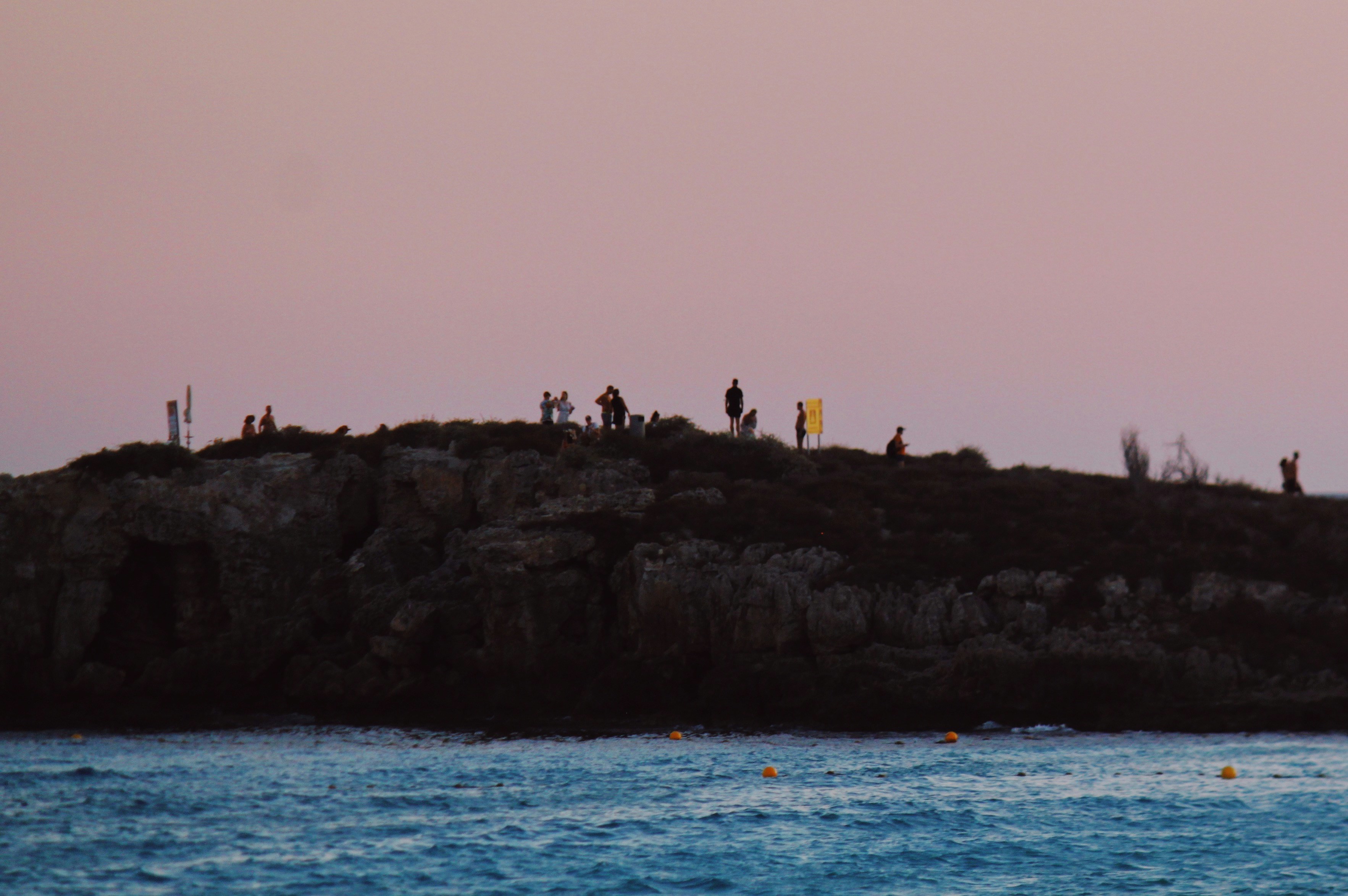 a group of people standing on top of a cliff