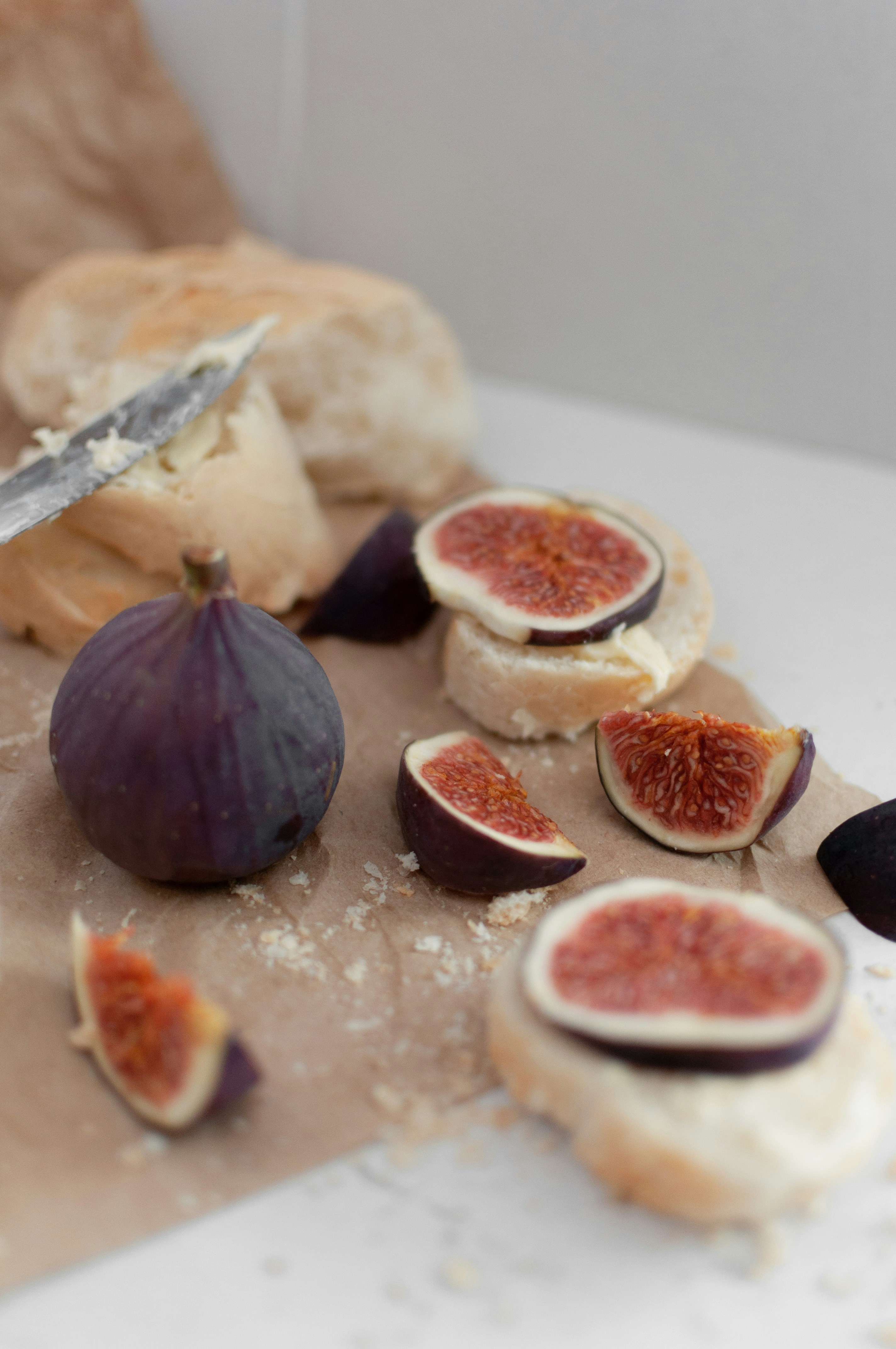 figs and bread on a cutting board with a knife