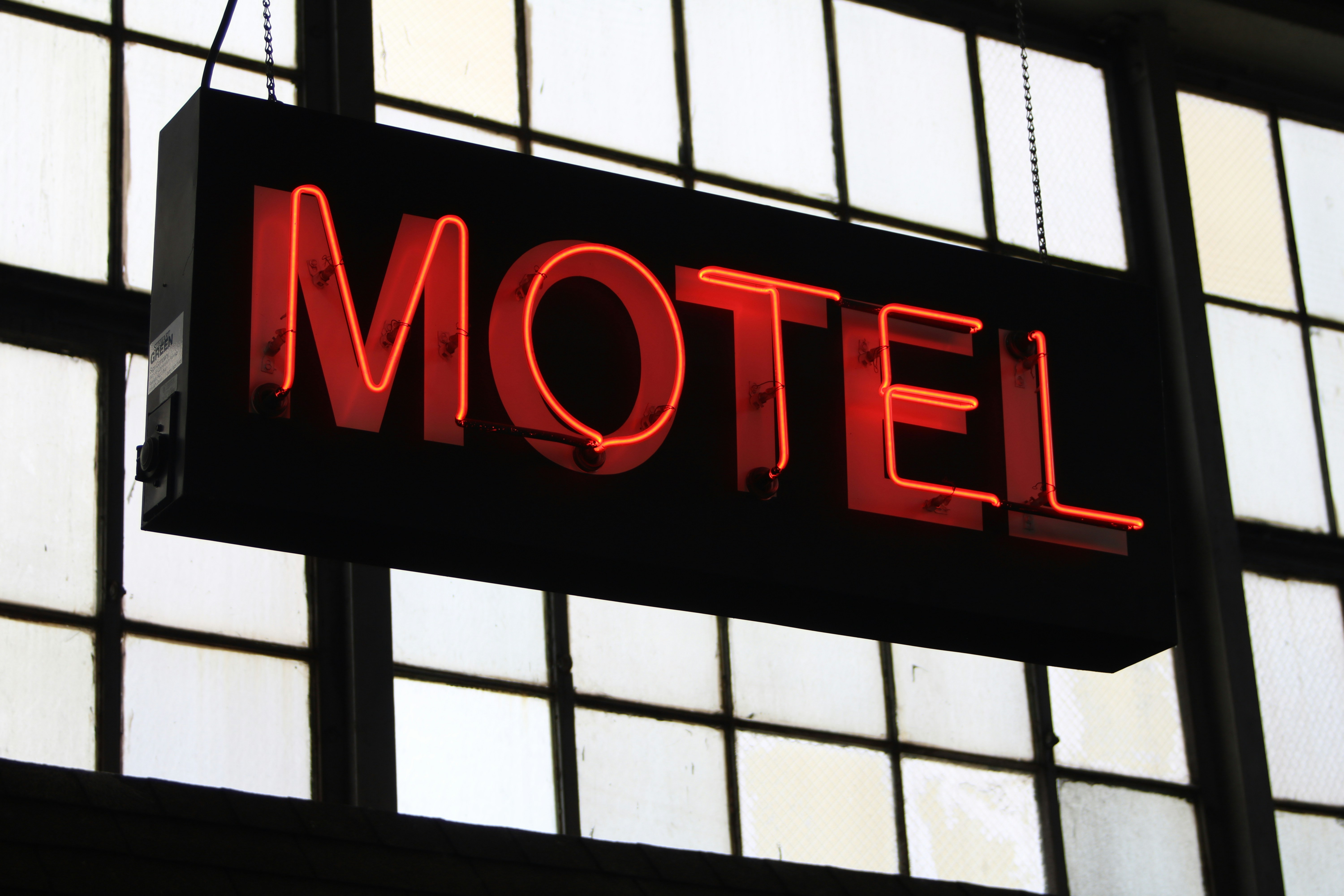 A neon sign hanging from the side of a building photo – Free North ...