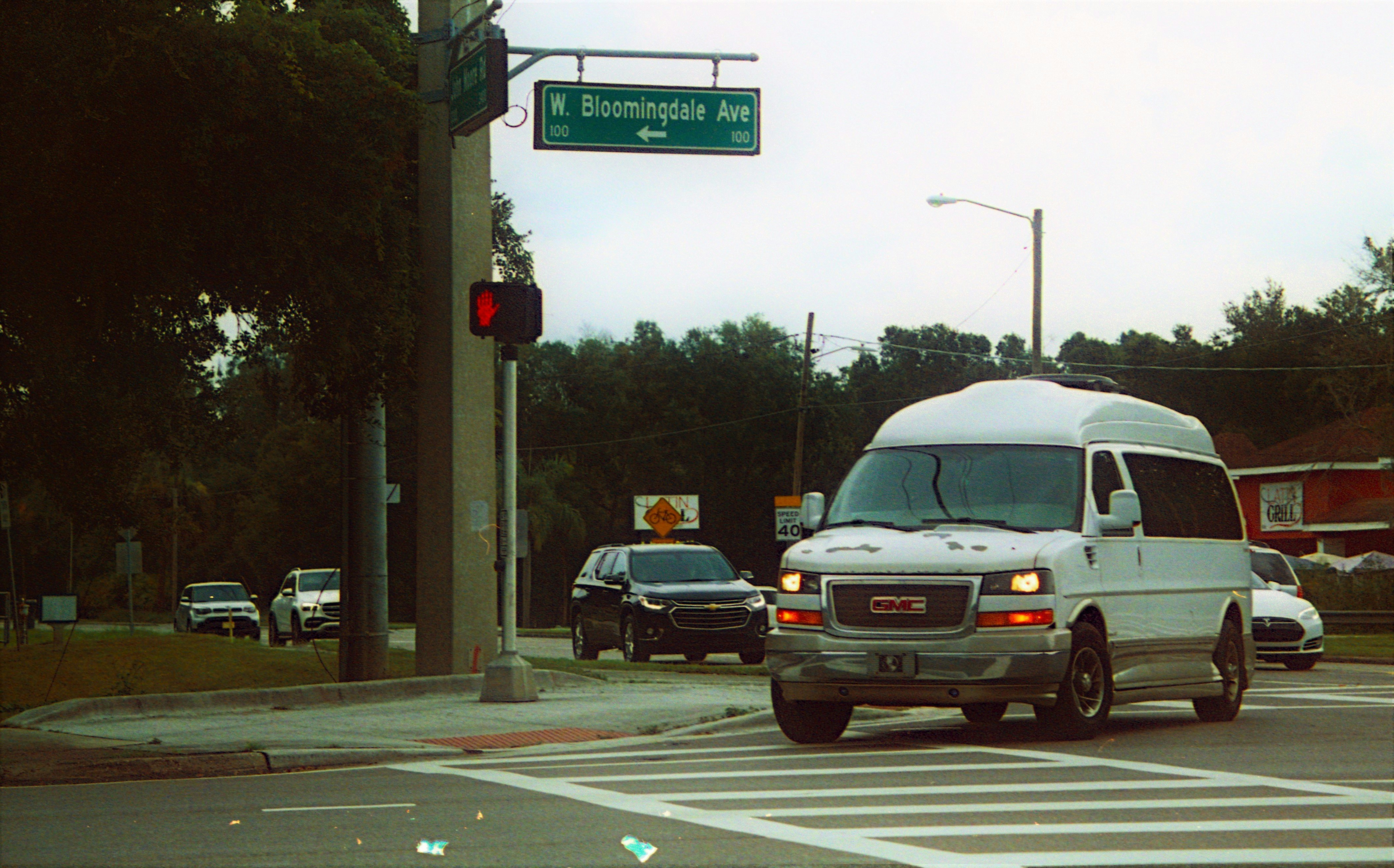 A white van driving down a street next to a traffic light photo – Free ...