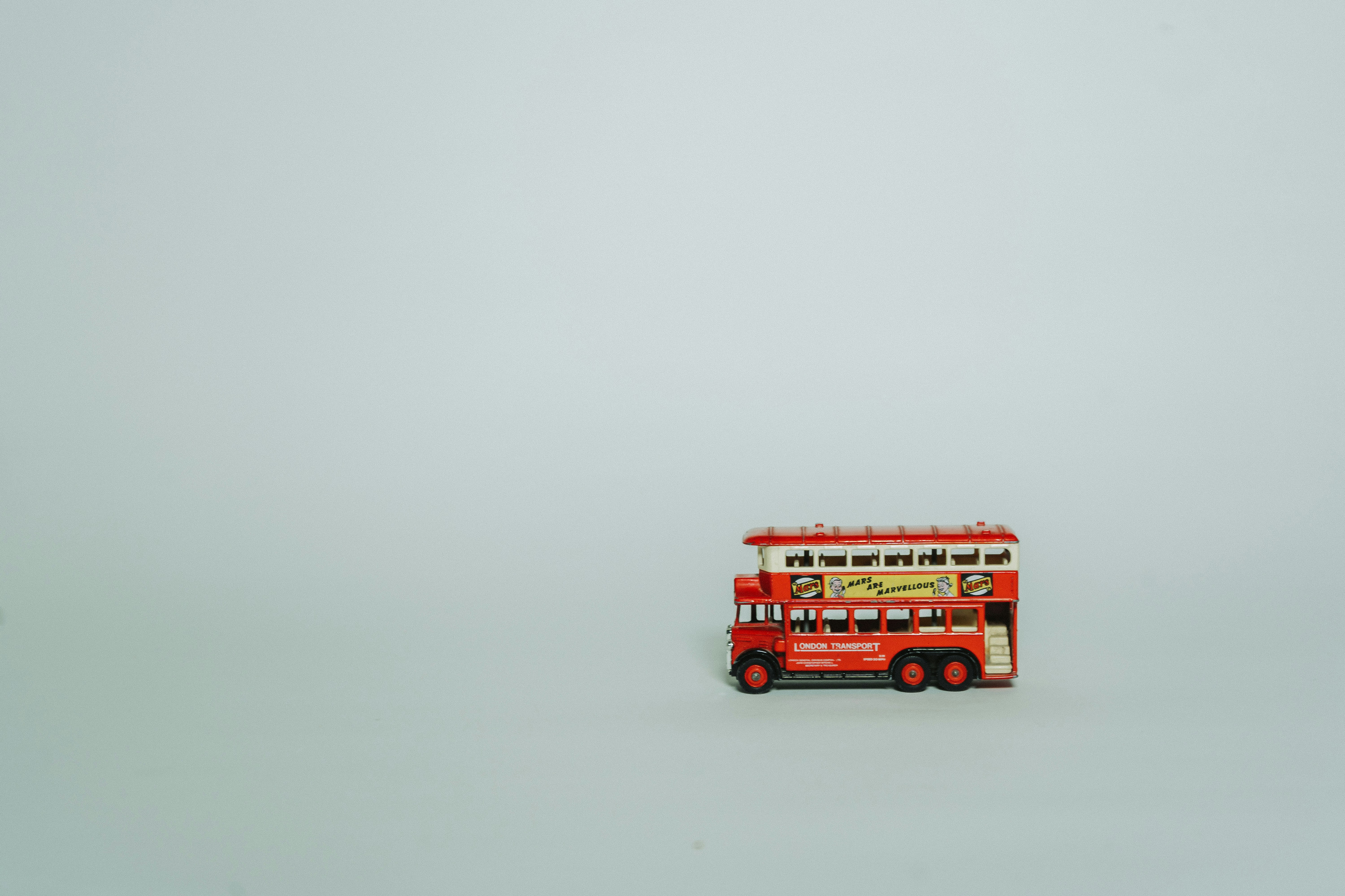 Tiny Red Bus, Big Studio: A Toy Vehicle on a Vast Minimal Backdrop