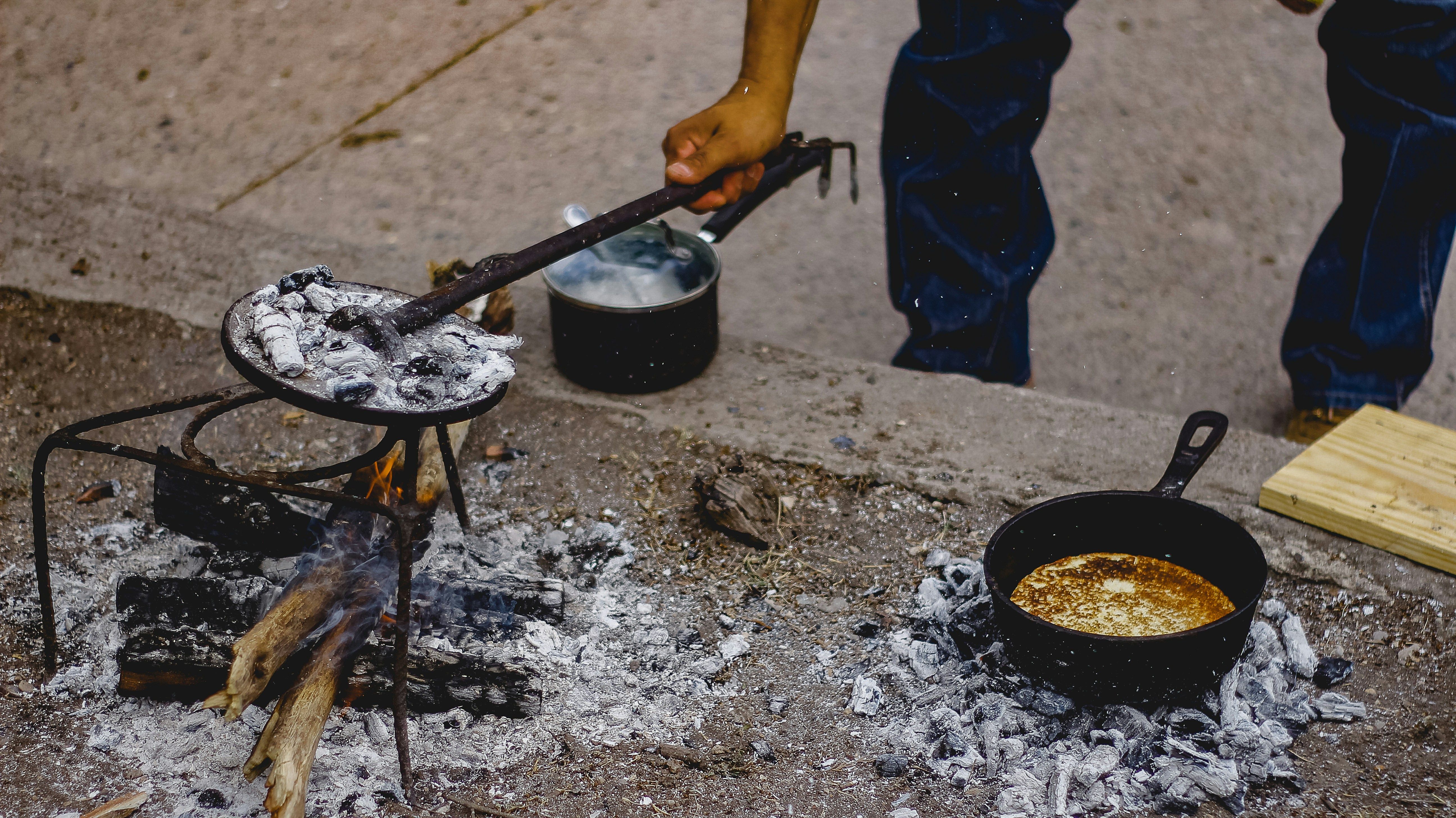 A person cooking food on a grill on the side of the road photo – Free ...