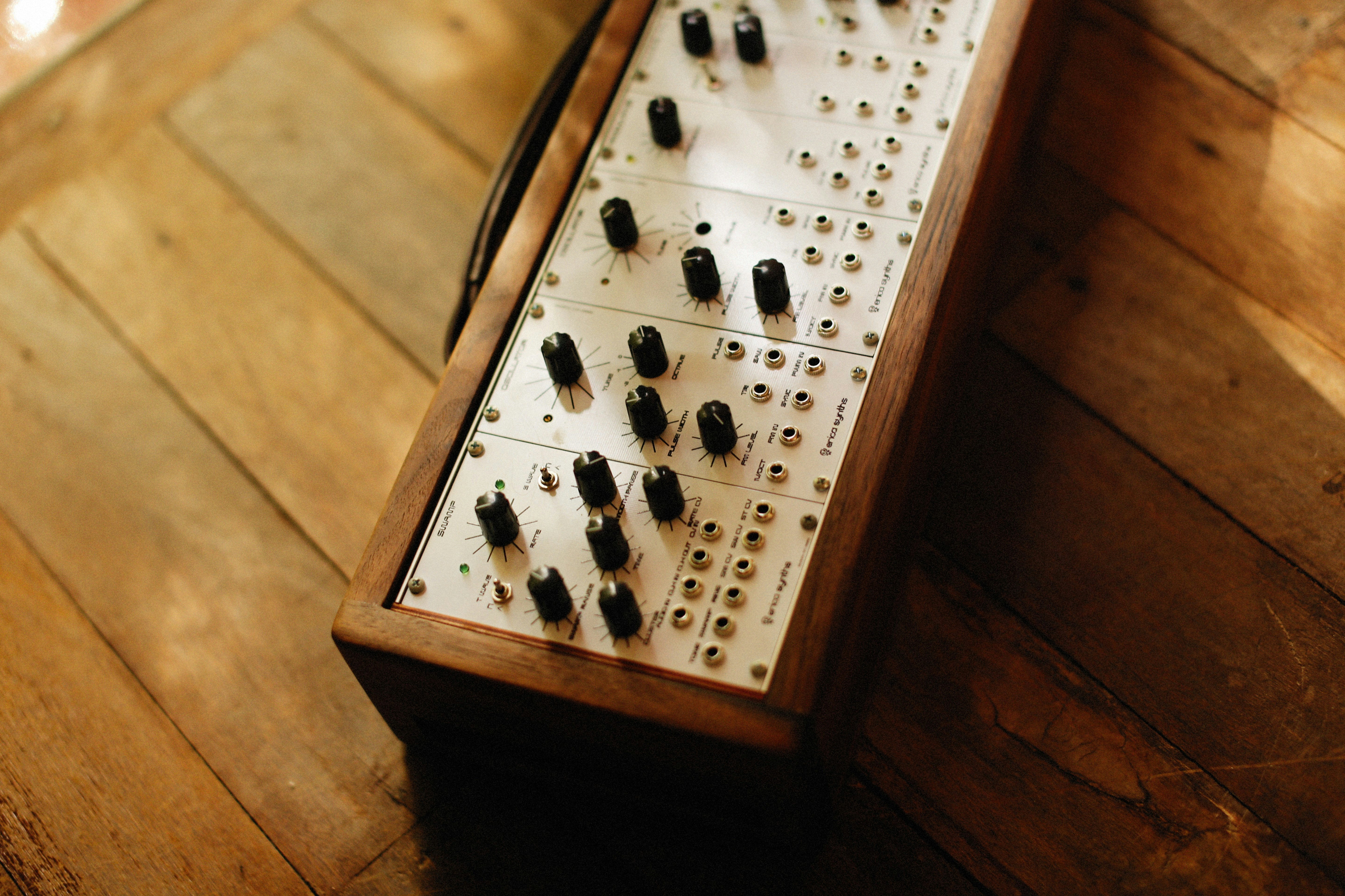 Tilted Oscillators: A Vintage Modular Synthesizer Sprawled Across a Wooden Floor