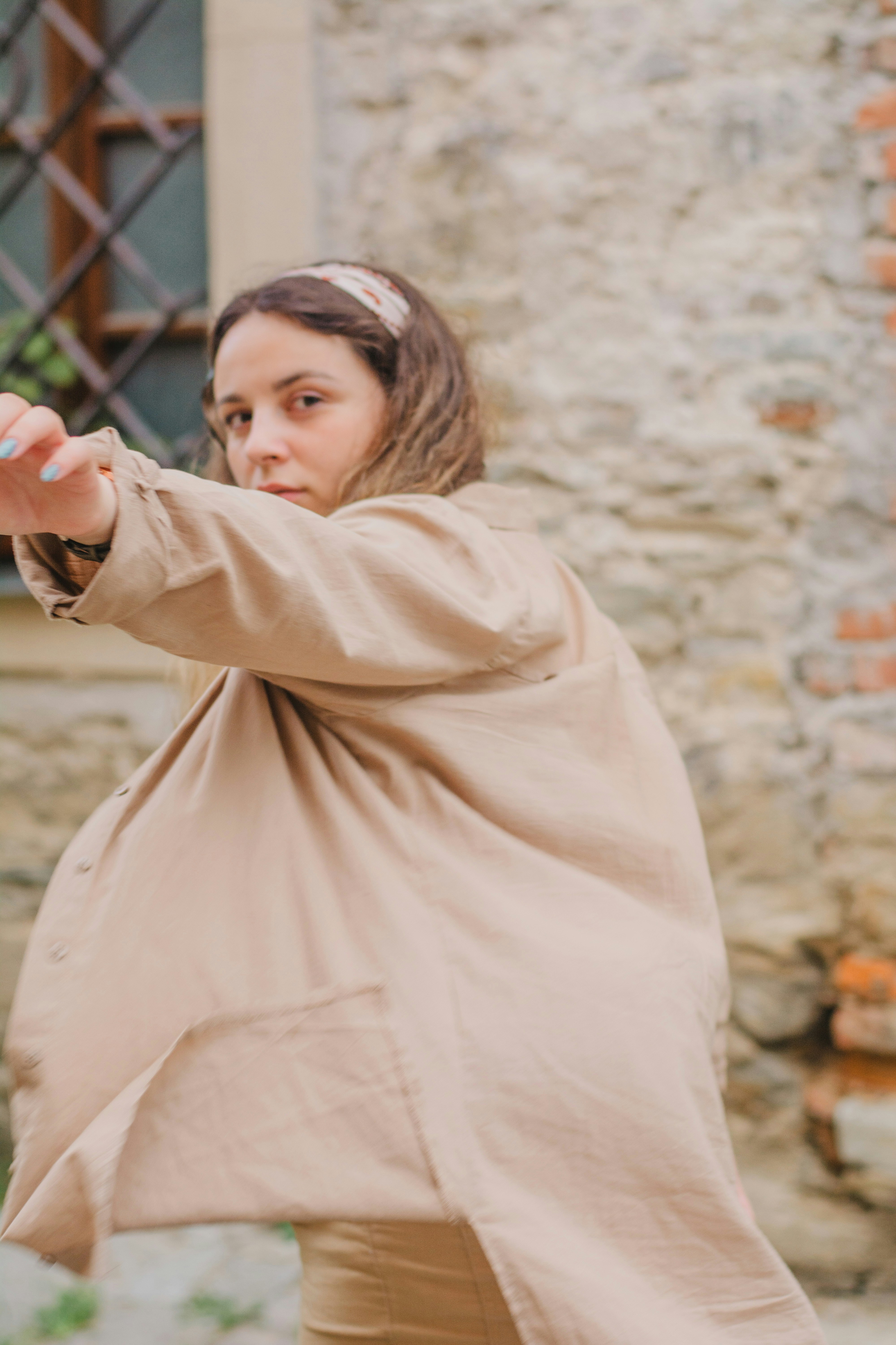 A woman in a beige coat is holding a gun photo – Free Portrait Image on ...
