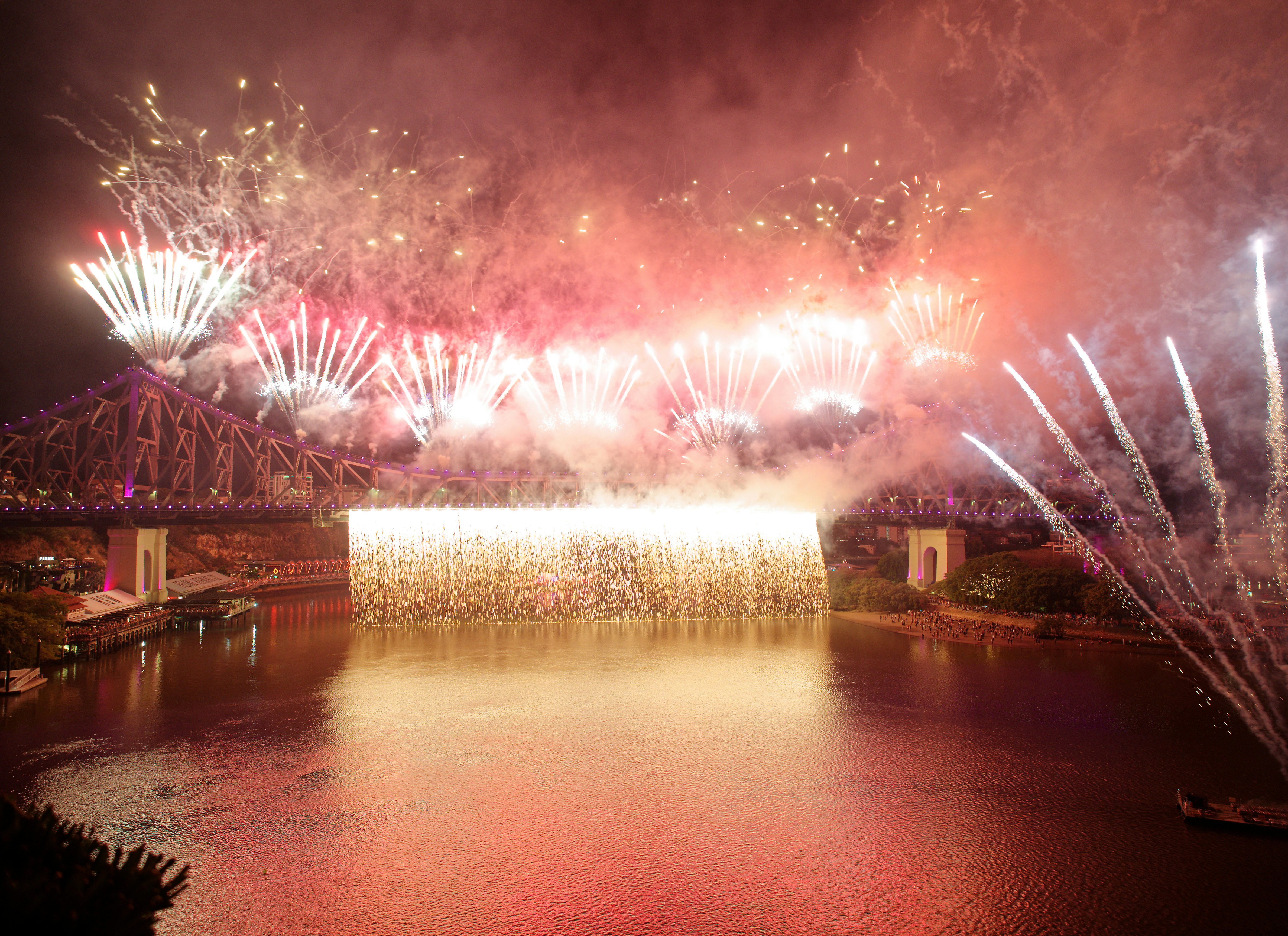 Bridge Under Fireworks: Riverside Celebration Illuminates the Night