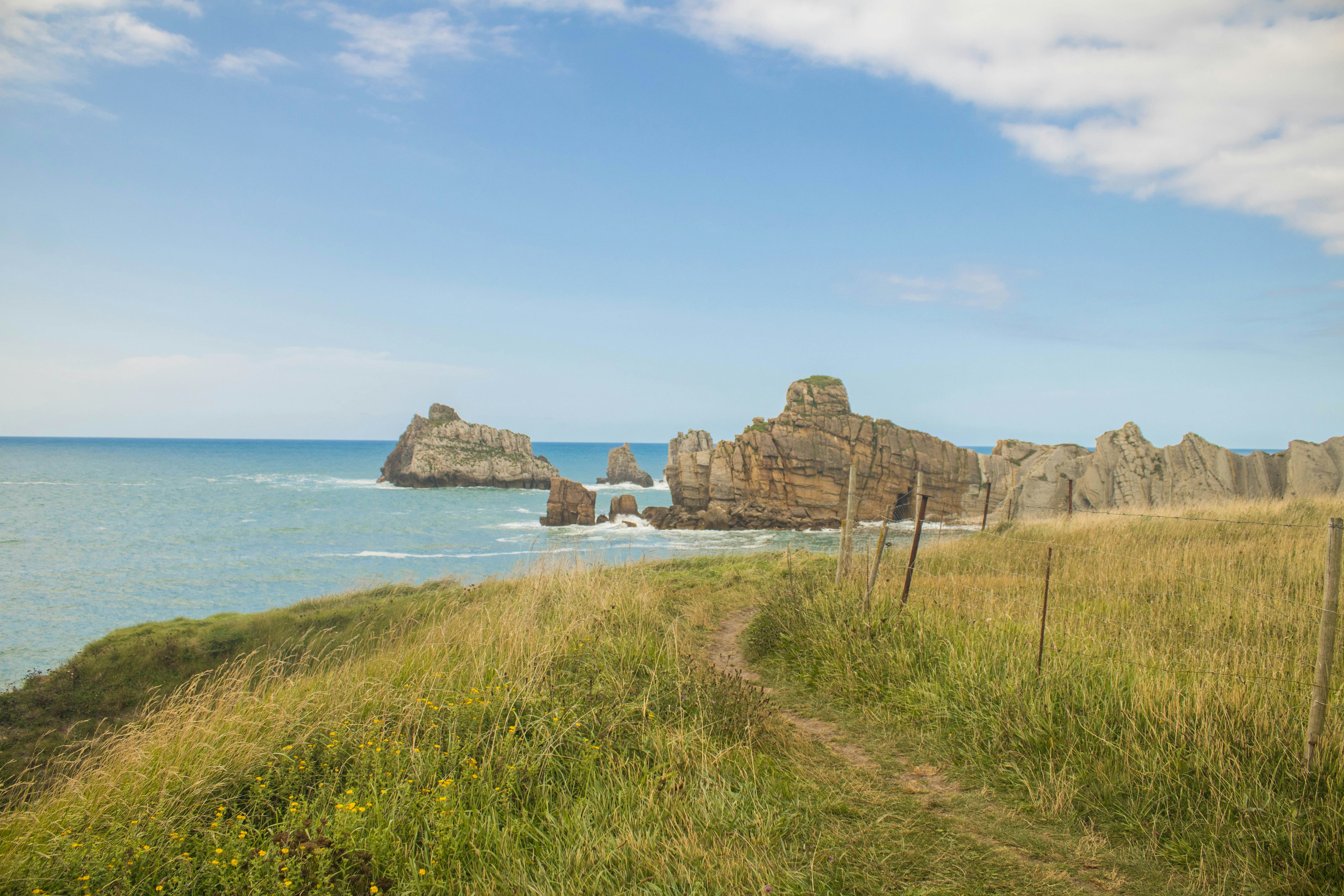 Trail to the Weathered Sea-Rock Promontory under a Bright Coastal Sky