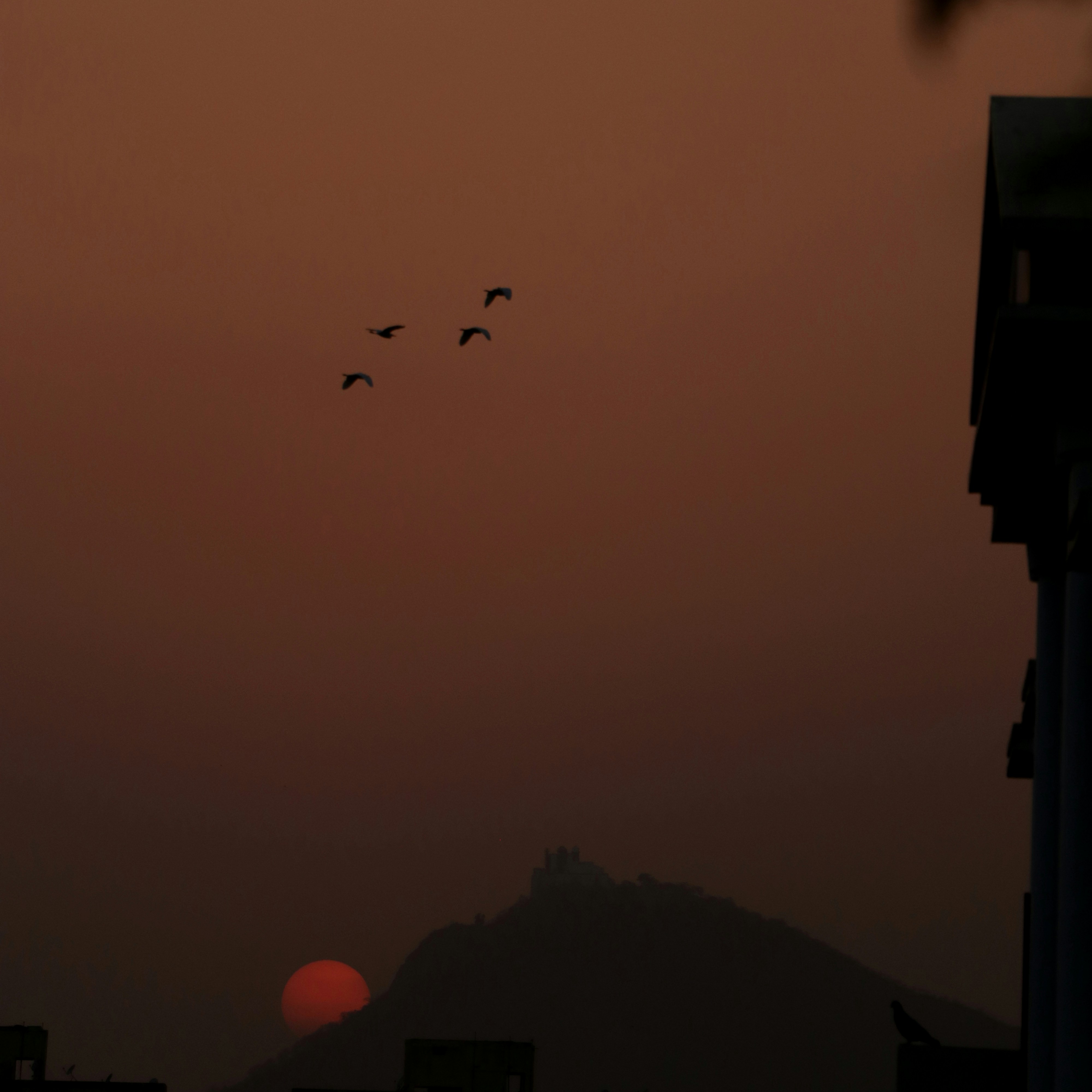 Sunset Silhouettes: Hilltop Fortress Beneath a Crimson Sky