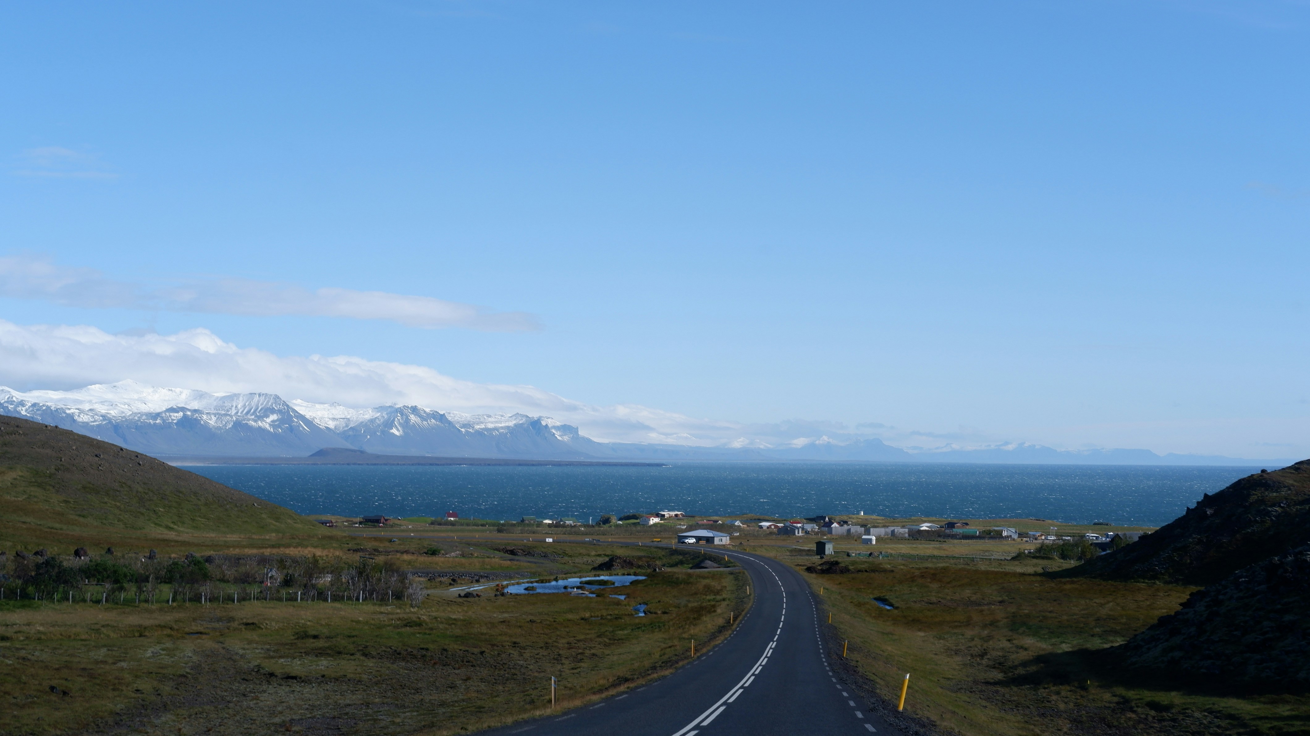 Winding Road to the Blue Horizon over a Snow-kissed Icelandic Coast