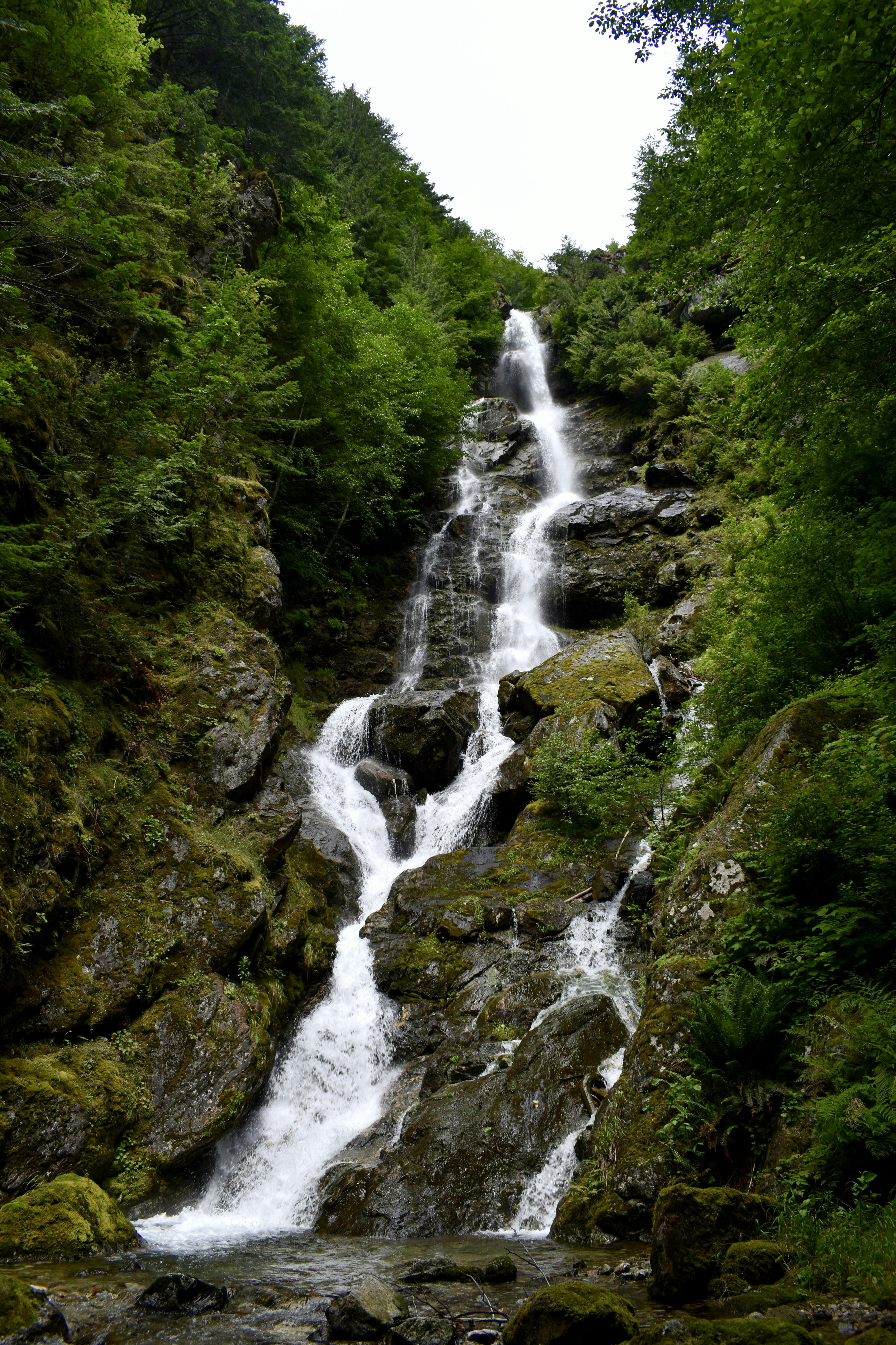 A waterfall in the middle of a forest photo – Free Waterfall Image on ...